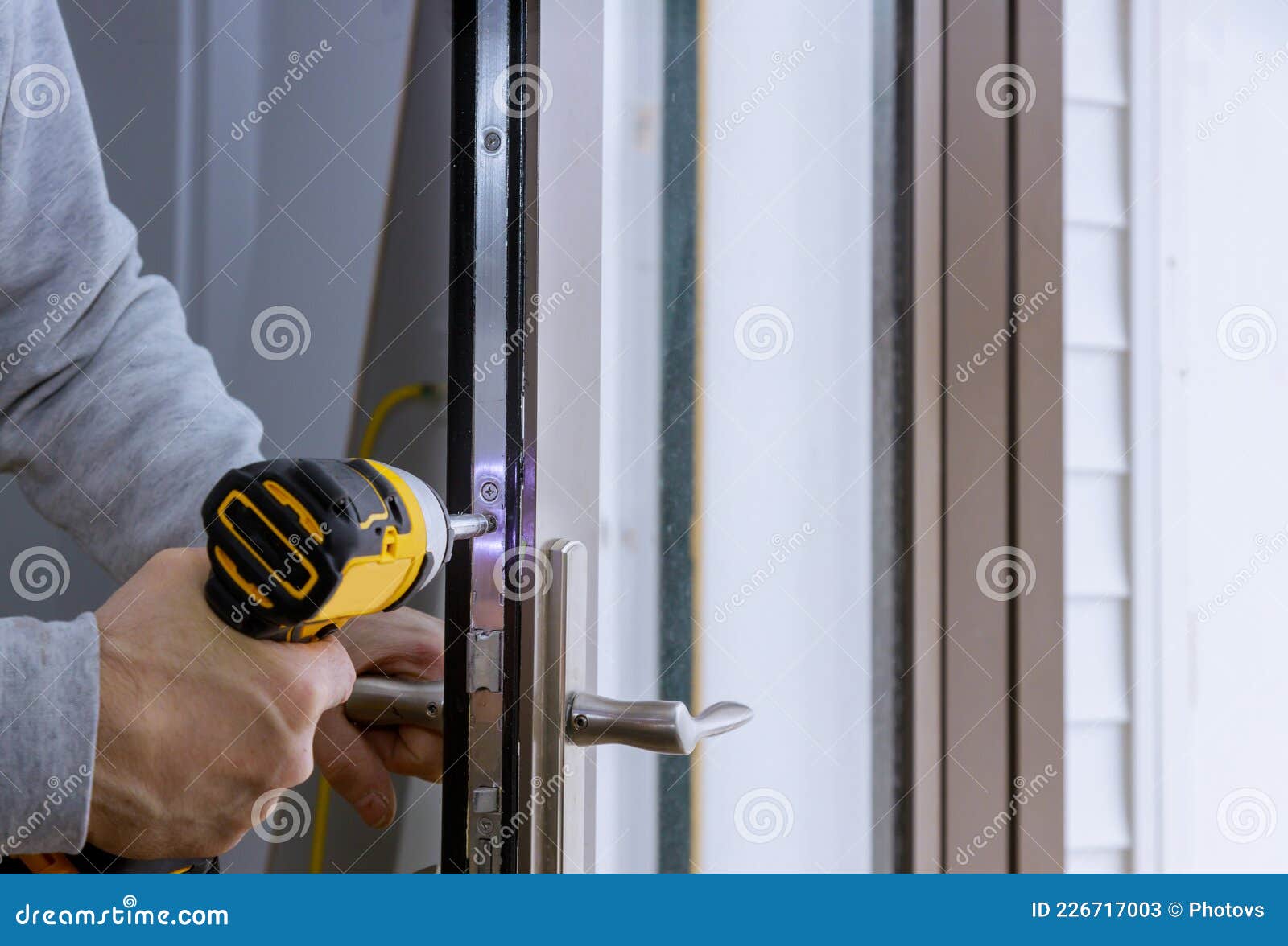 Locksmith Hand Holds the Screwdriver in Installing New House Door Lock ...