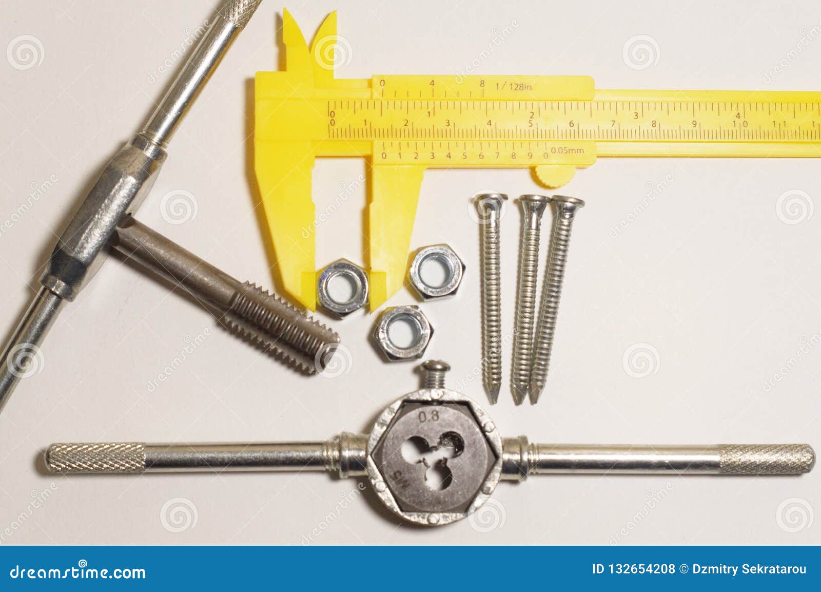 Locksmith Tool. Tap for Cutting Threads, Micrometer and Nuts on a White ...