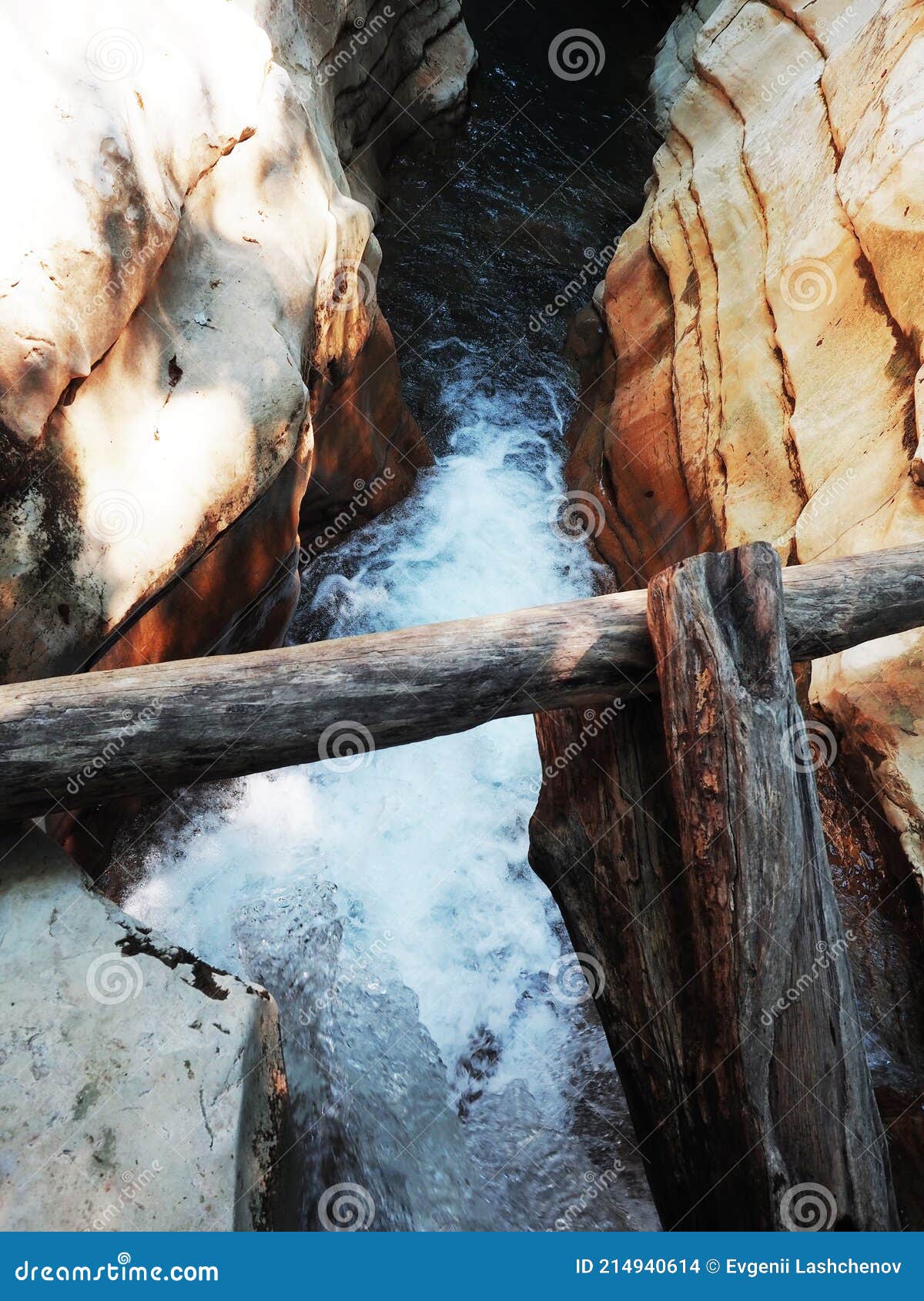 The Log Lies between the Rocks Above the Bubbling Foamy Narrow River ...