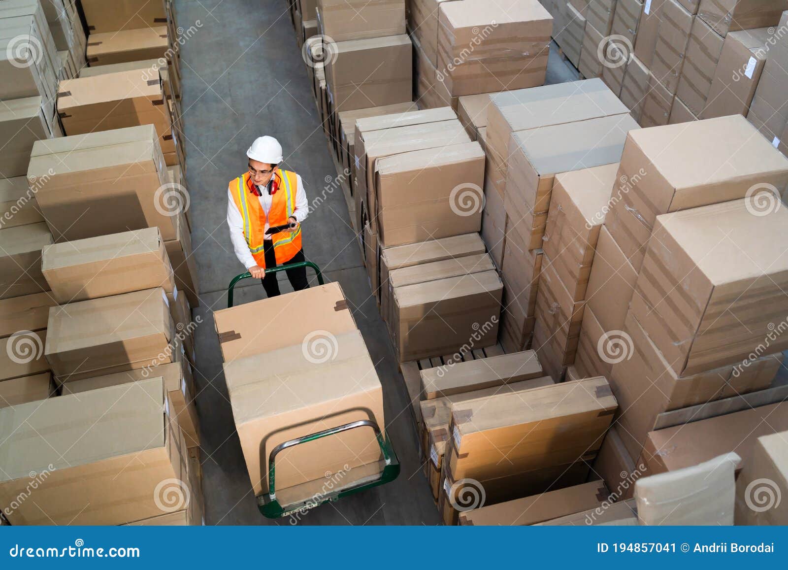 Logistic Warehouse Worker Delivering Boxes on a Trolley. Stock Image ...