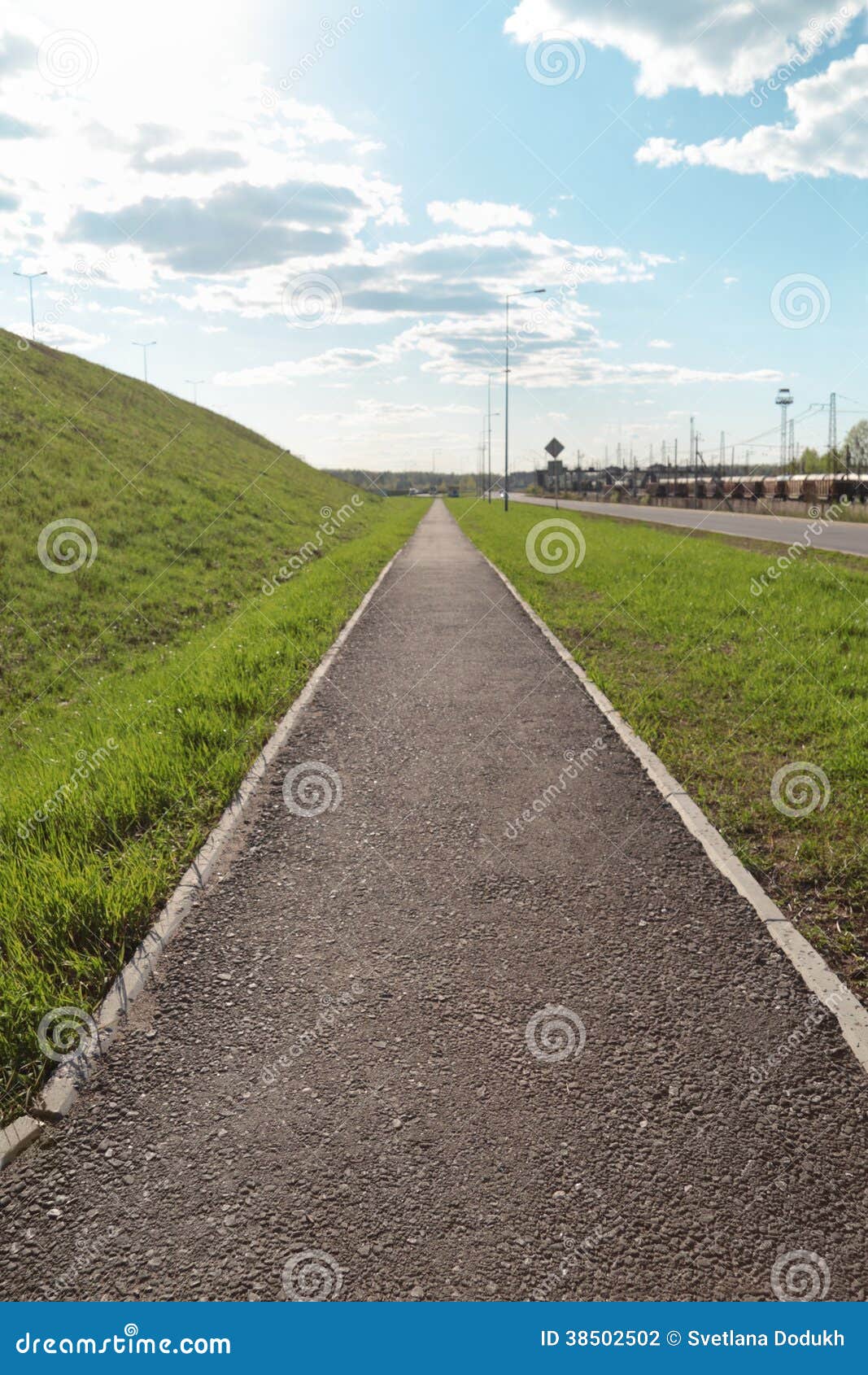 Long Asphalt Path Next To Green Hill on Sunny Spring Day Stock Photo ...