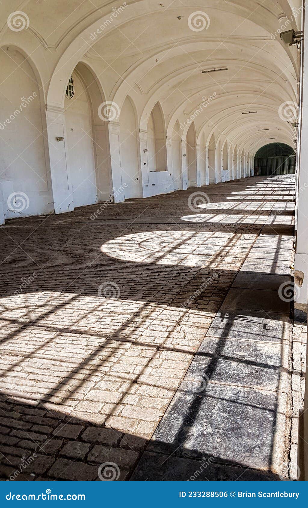 Long Corridor through Archway with Repeating Shadow Patterns Stock ...
