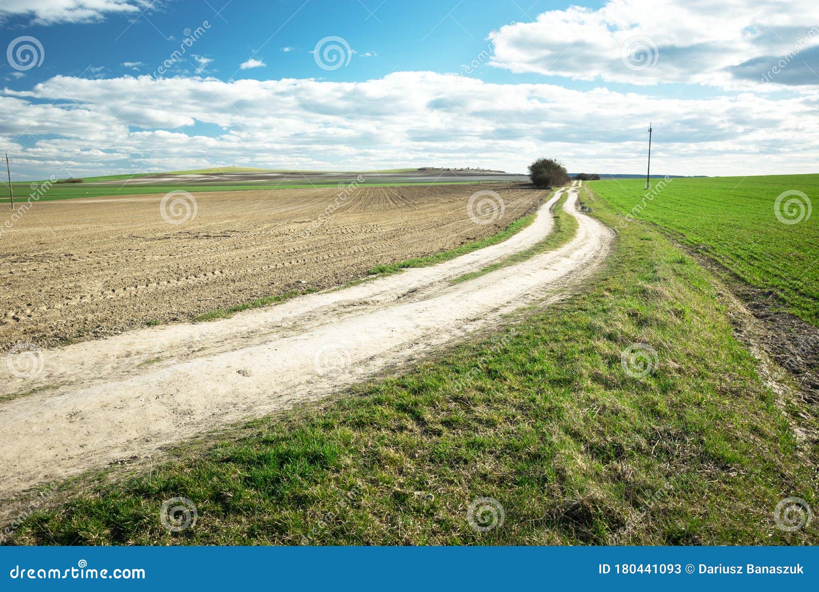 A Long Dirt Road through Fields, Horizon and Clouds on a Blue Sky Stock ...
