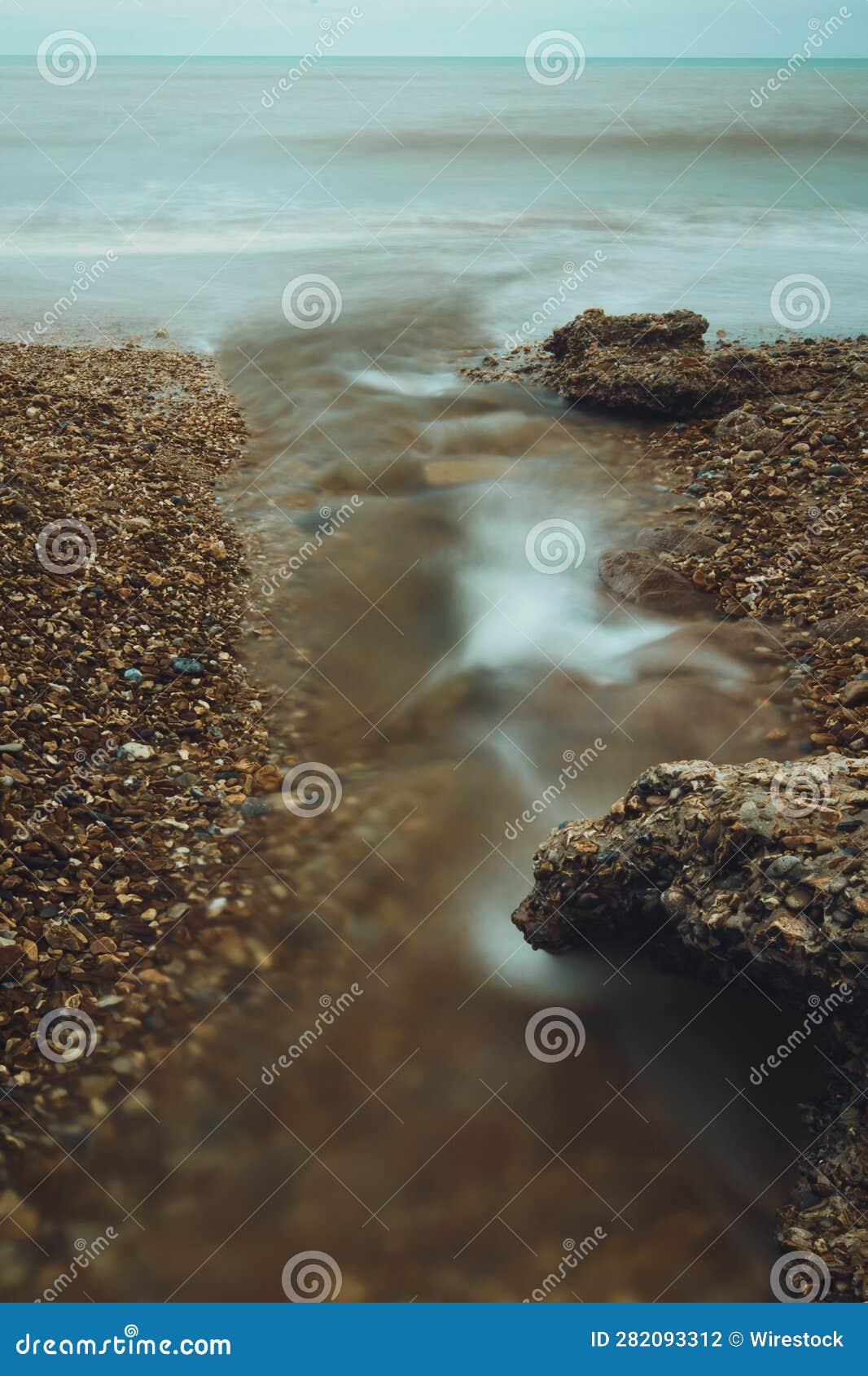 Long Exposure Shot of a Stream with the Background of a Stony Shore ...