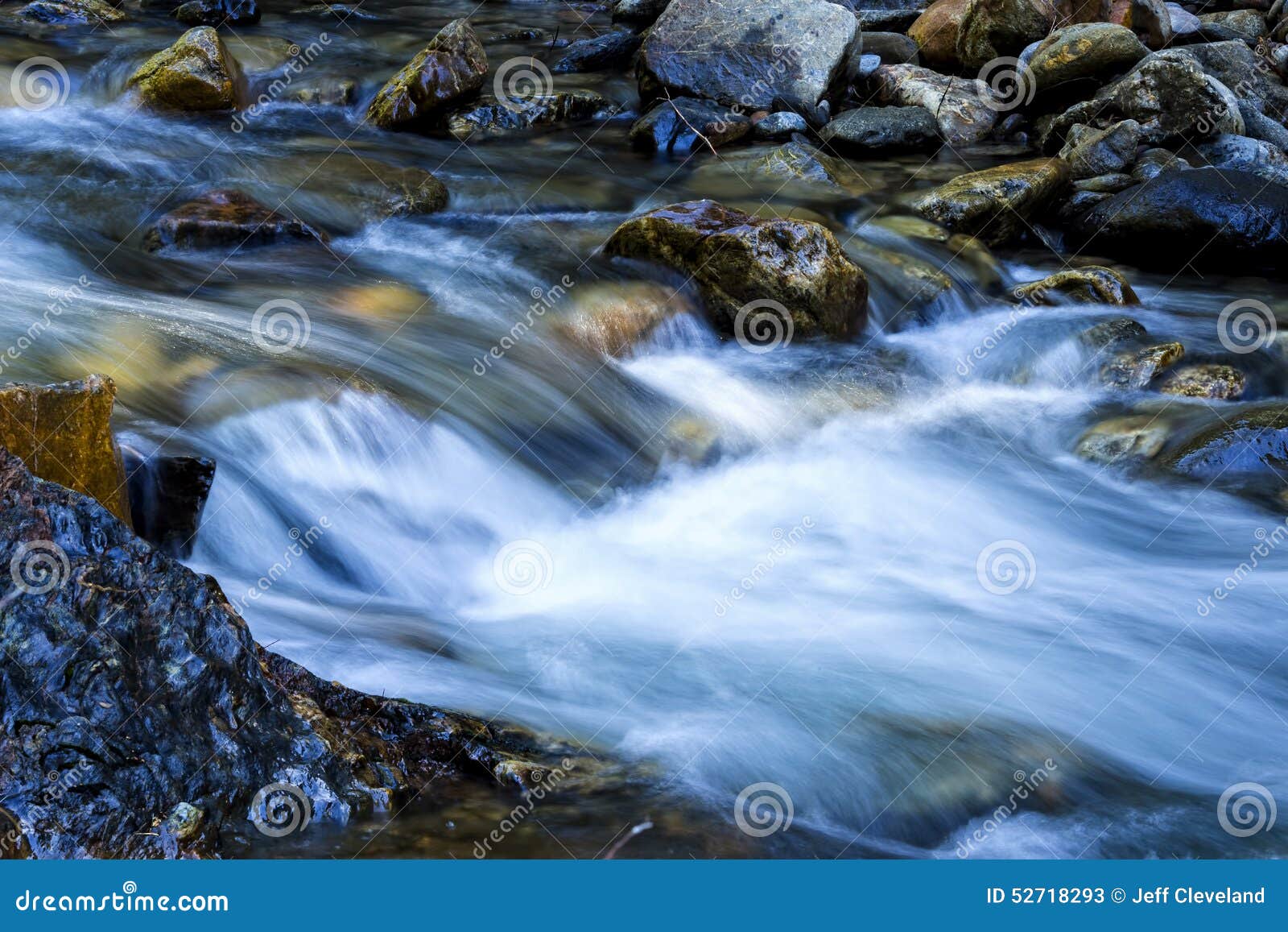 Stream Flowing Into A River Among Wild Plants, Green Grass And A Hill ...