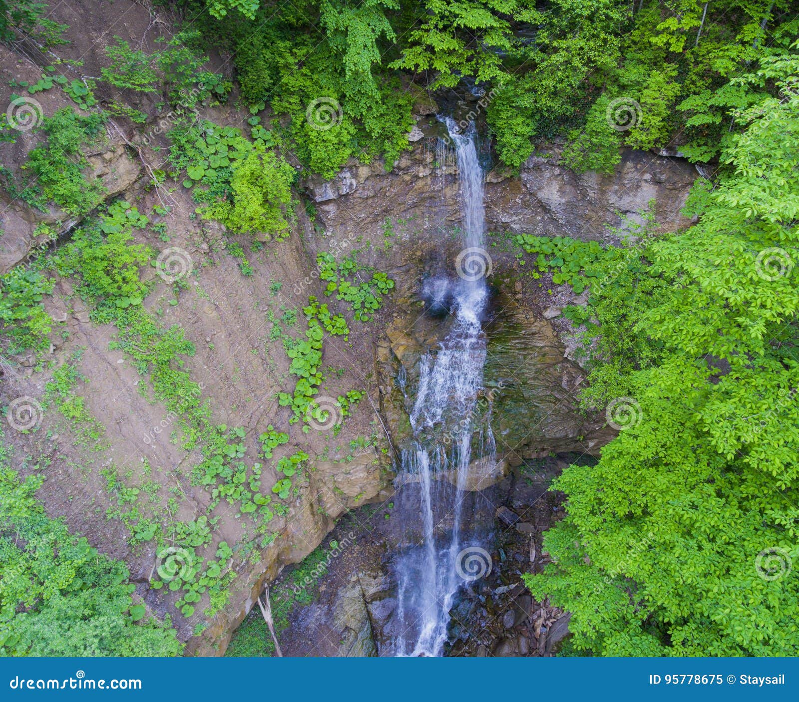 Long the Flow of the Waterfall Cascading from the Cliff. Aerial Stock ...