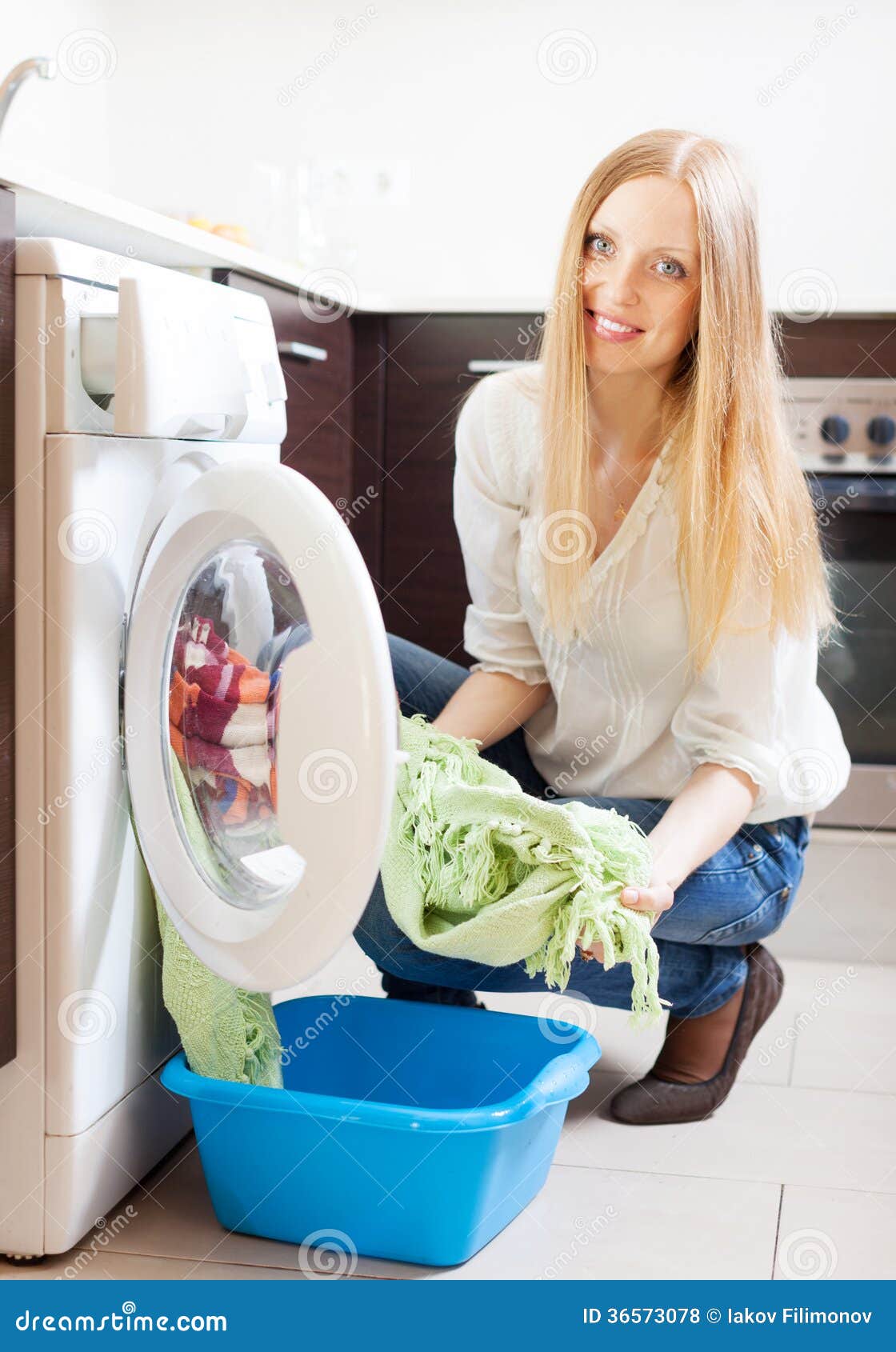 Long-haired Woman Loading Clothes into the Washing Machine Stock Photo ...