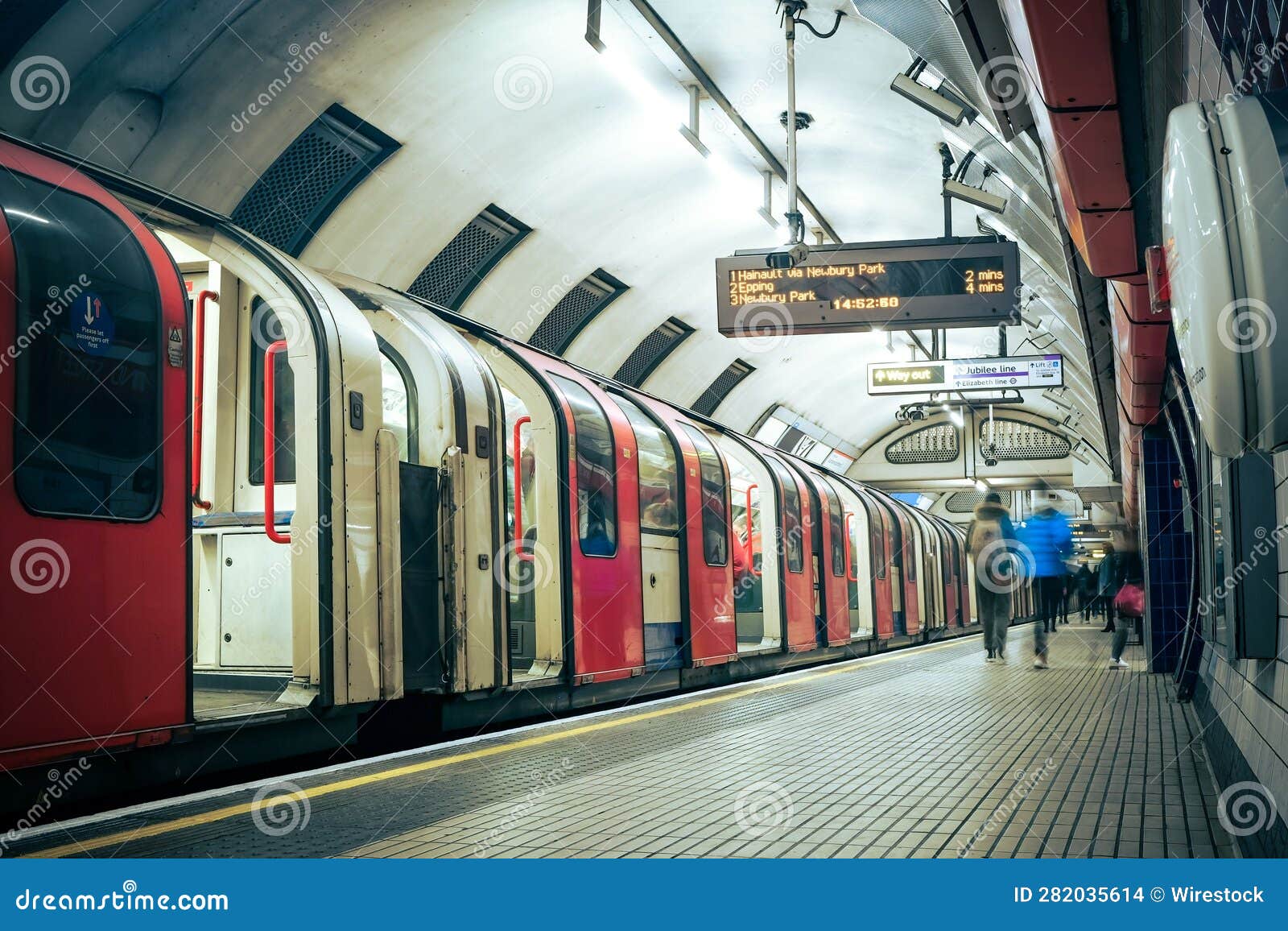 Long Passenger Train at a Railway Platform, with Commuters Walking by ...
