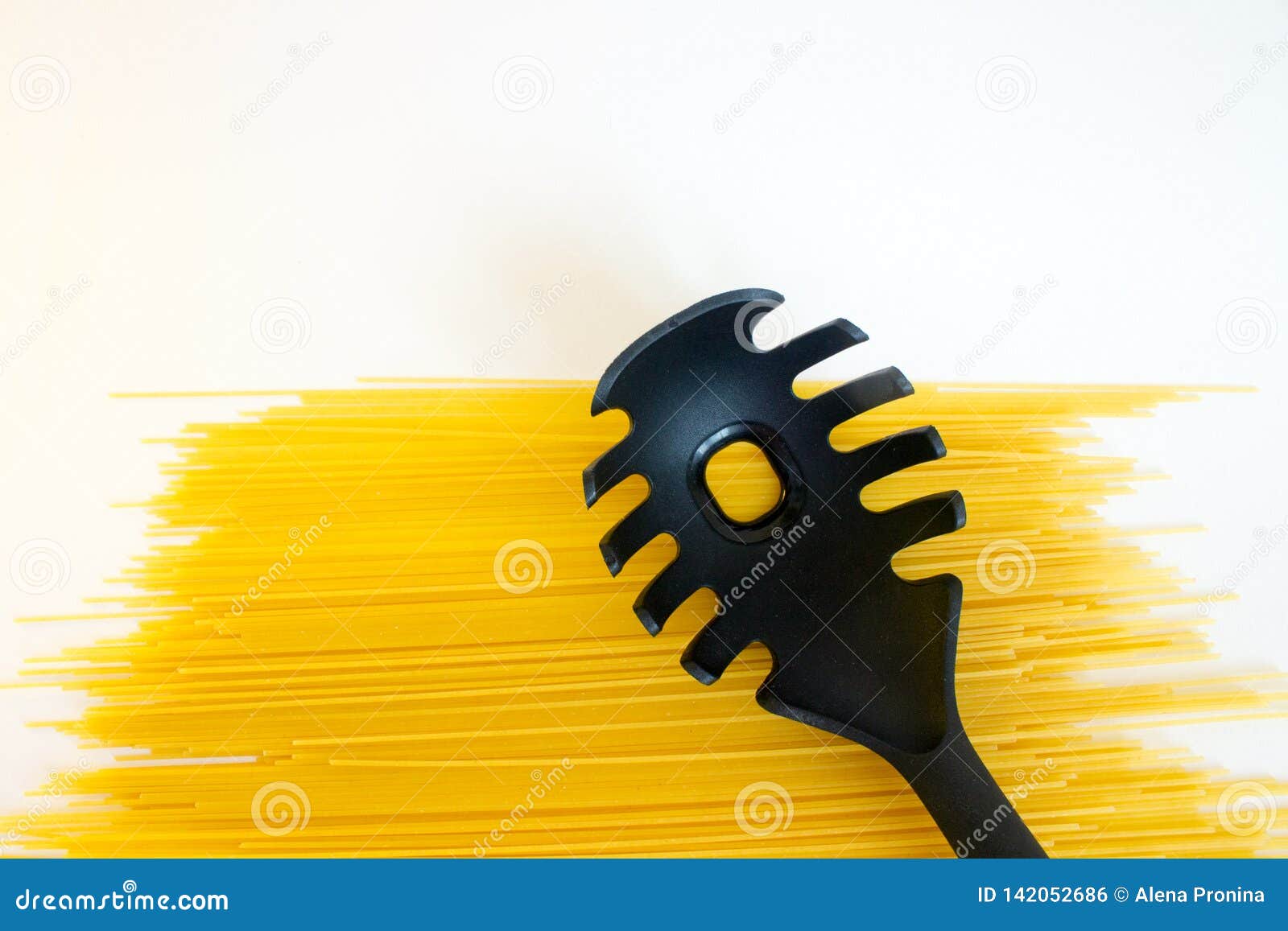 Long Raw Yellow Spaghetti with Black Plastic Spoon with Hole Isolated ...