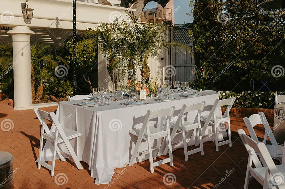 Long, Rectangular Table Covered in a White Tablecloth is Set for a ...