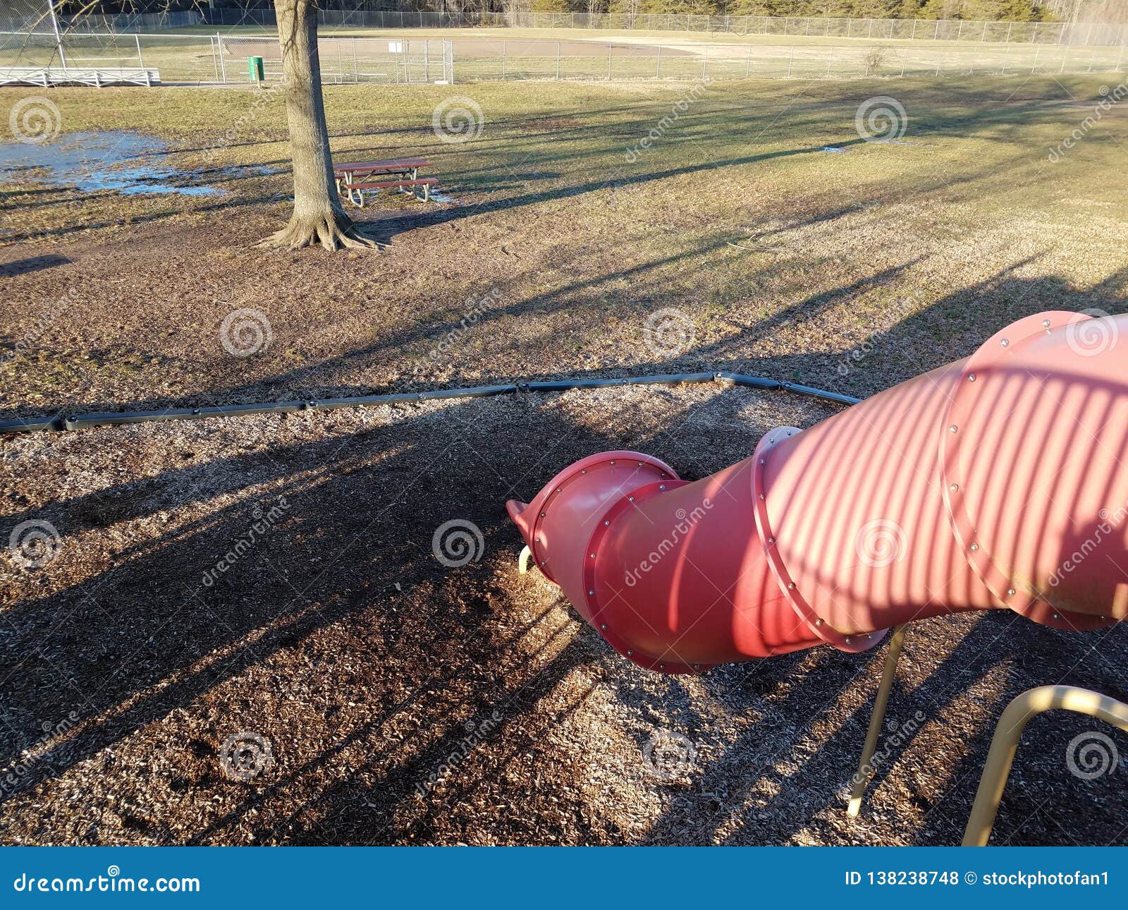 Long Red Slide on Playground Play Structure with Shadows Stock Photo ...