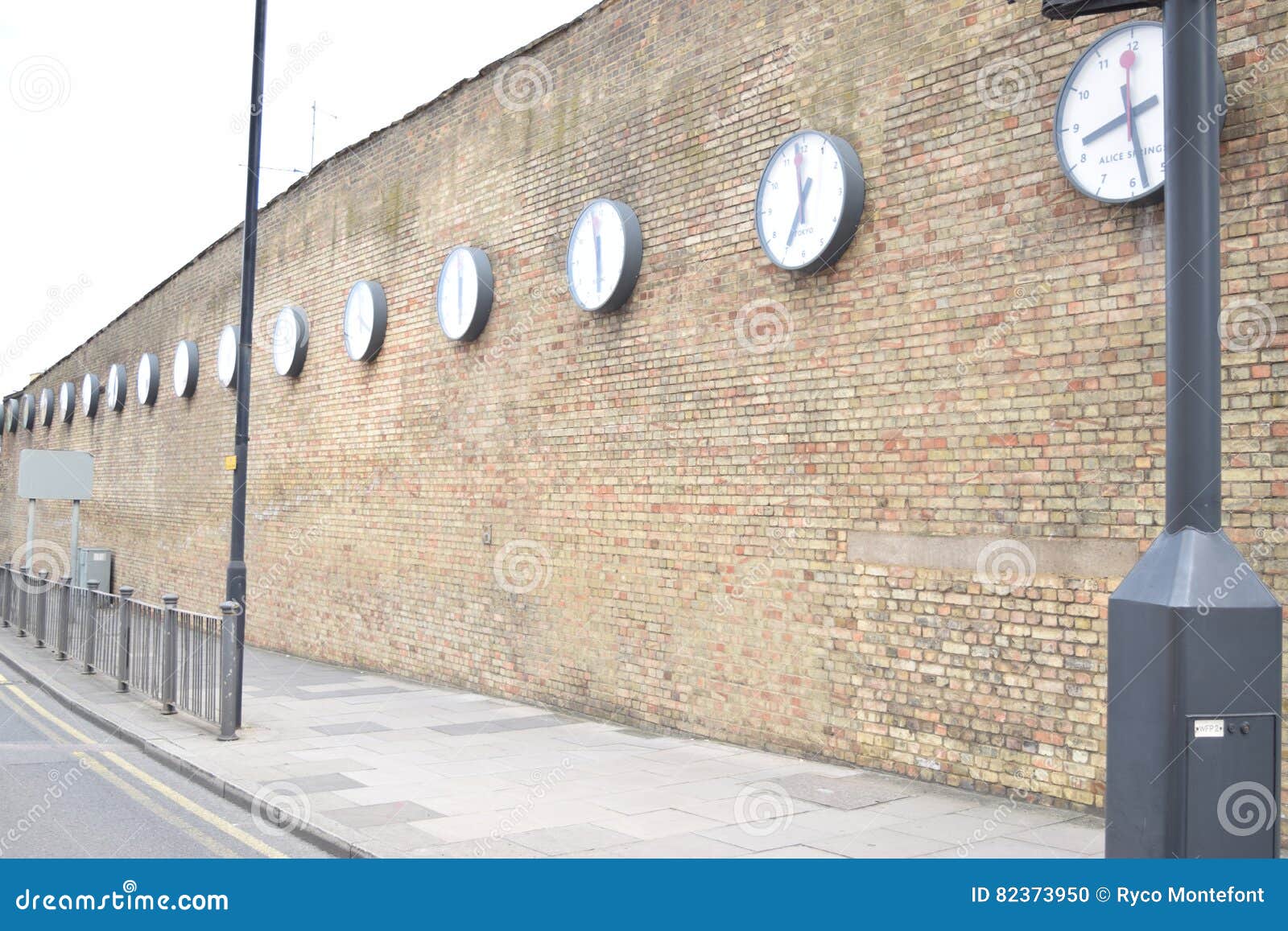 Long Row of Clocks on a High Brick Wall Editorial Image - Image of ...