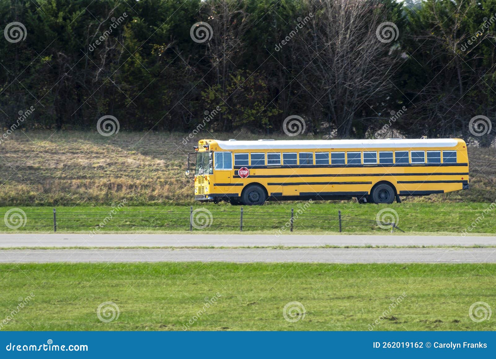 Long School Bus on an Empty Road Stock Photo - Image of empty, grass ...