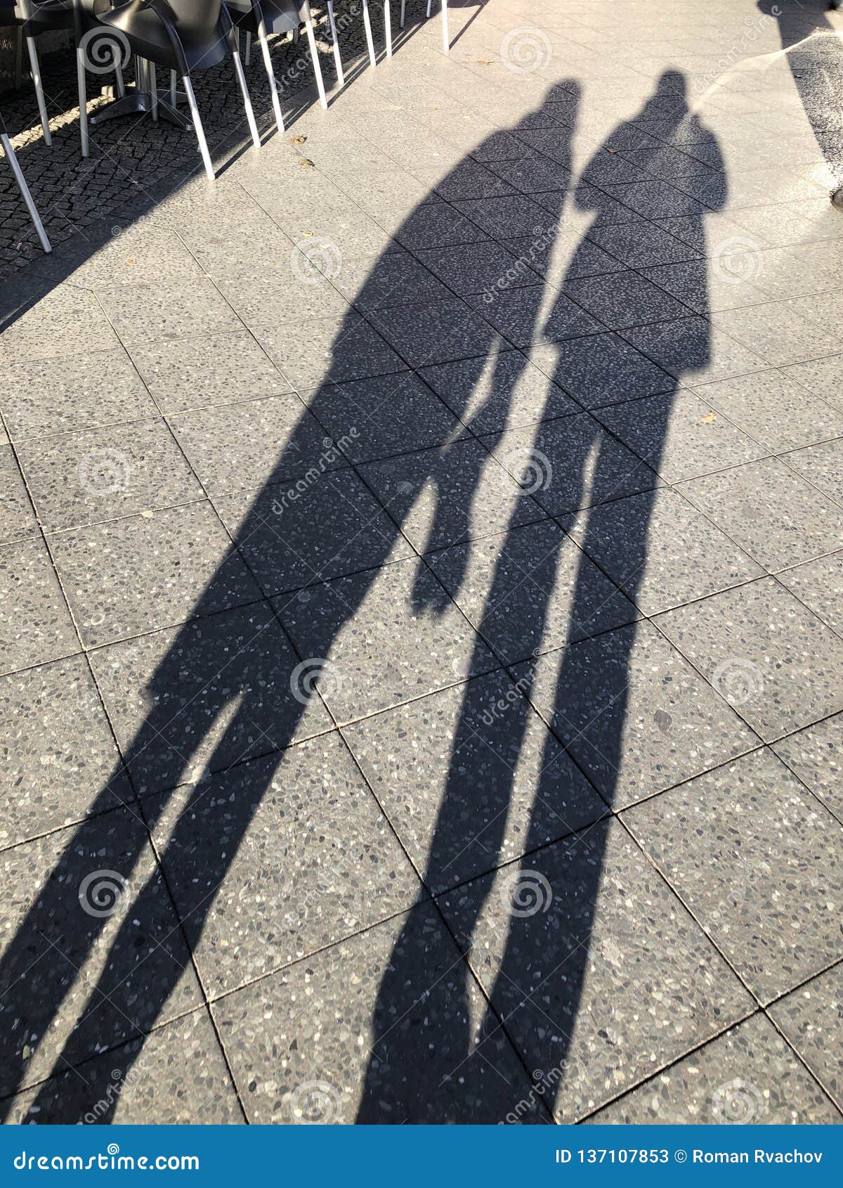 Long Shadows of Two People on the Sidewalk Stock Image - Image of ...