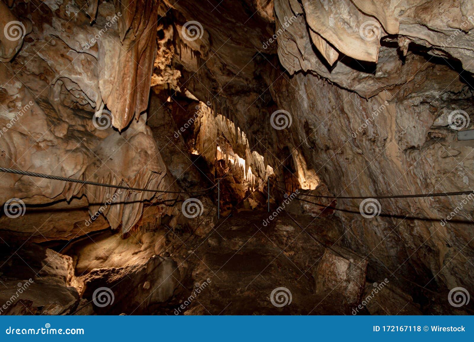 Long Shot of the Inside of a Cave with Low Ceiling and a Path Set with ...