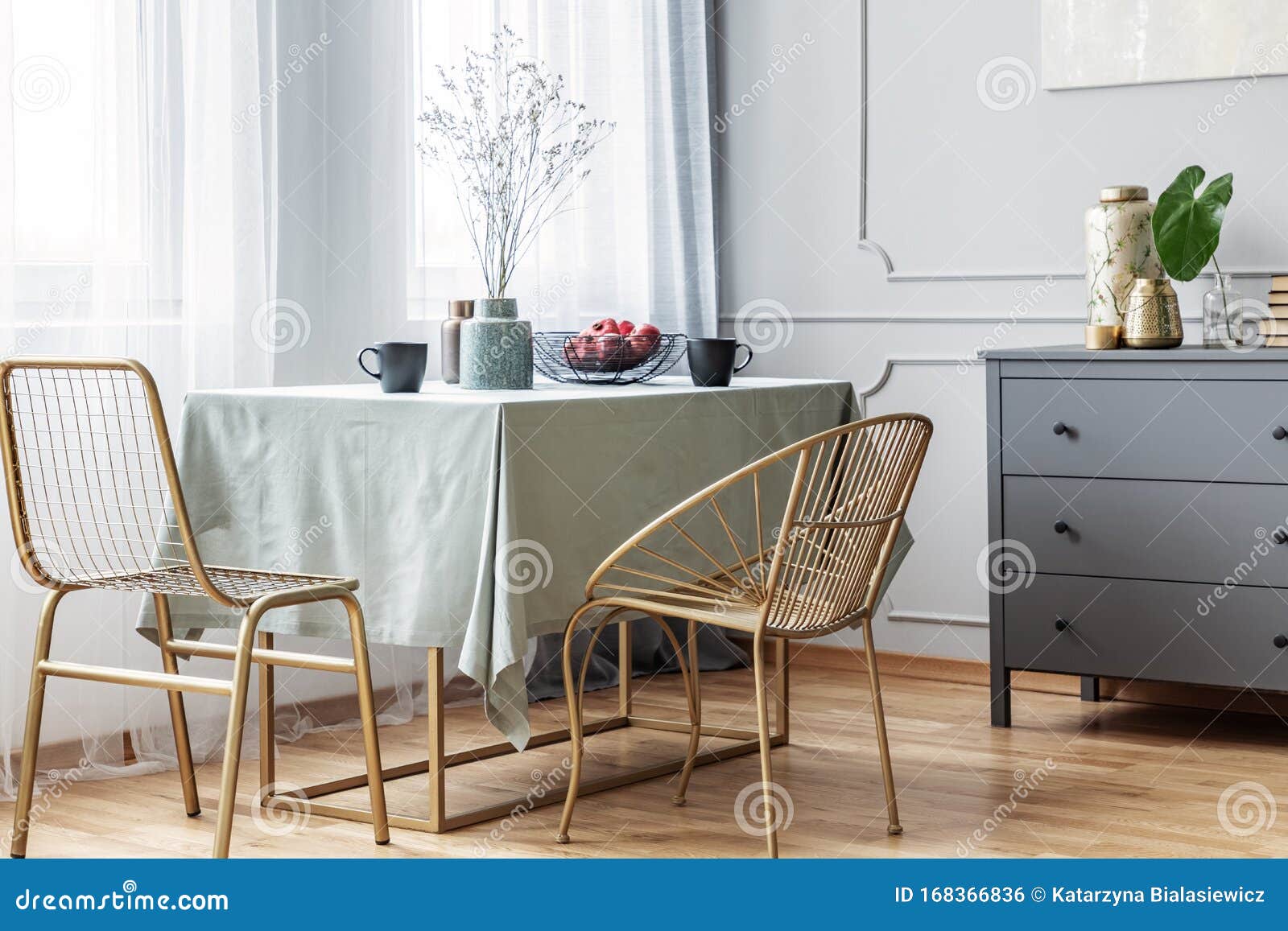 Table, Golden Chairs and Grey Commode in Beautiful Living Room Interior ...