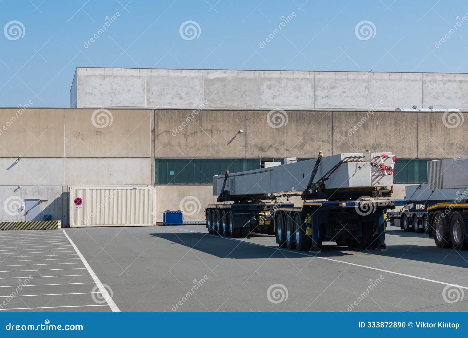 Long Trailer with Concrete Beams is Parked in Front of the Warehouse ...