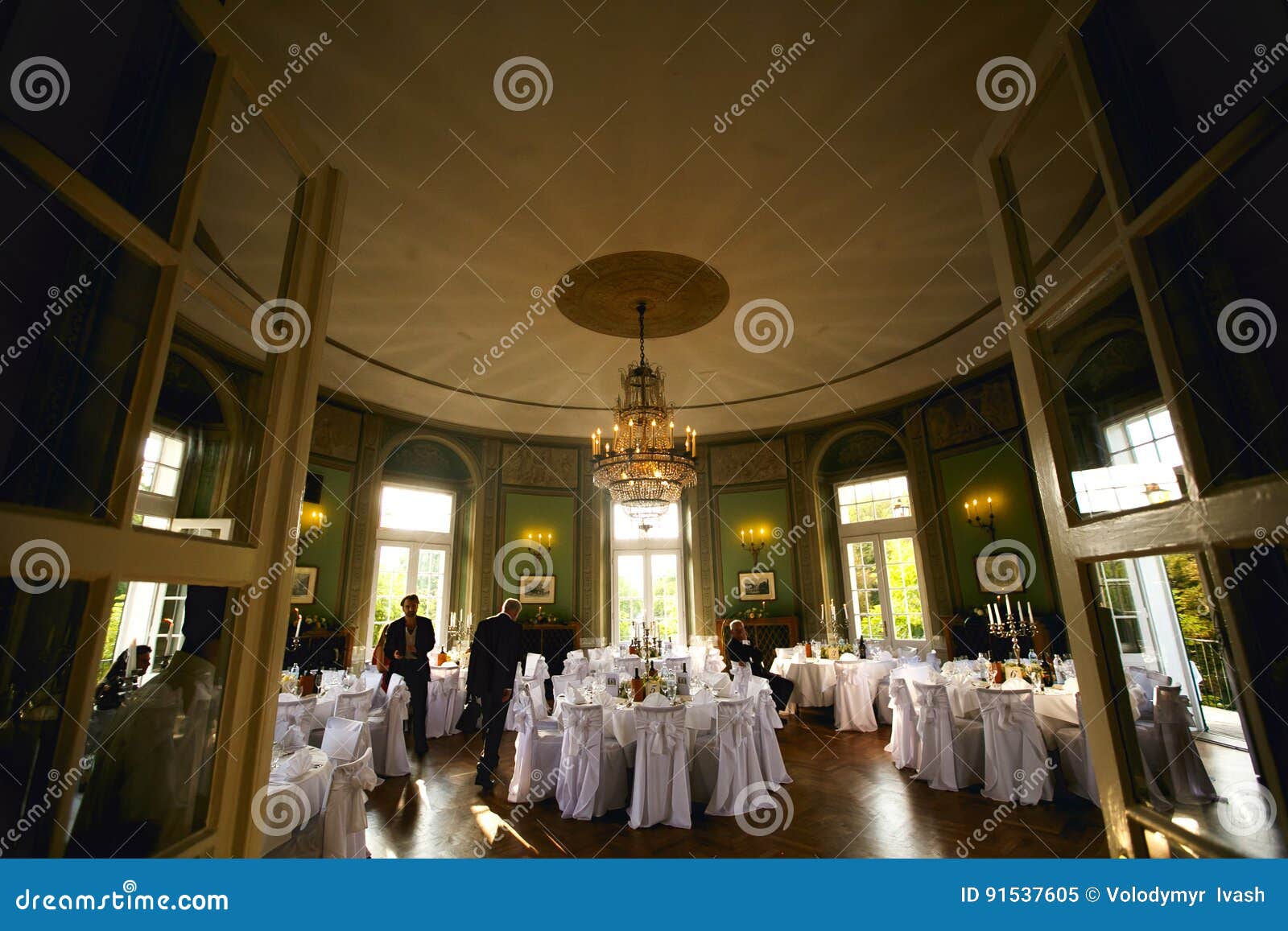 A Look from Behind the Glass Doors on a Restaurant Hall with Round ...