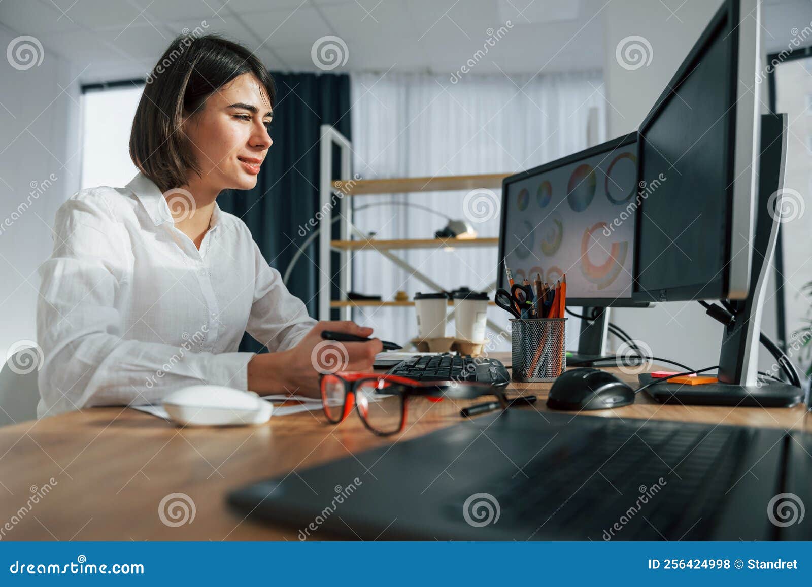 Looking at Display. Female Designer Working in the Office by Using PC ...