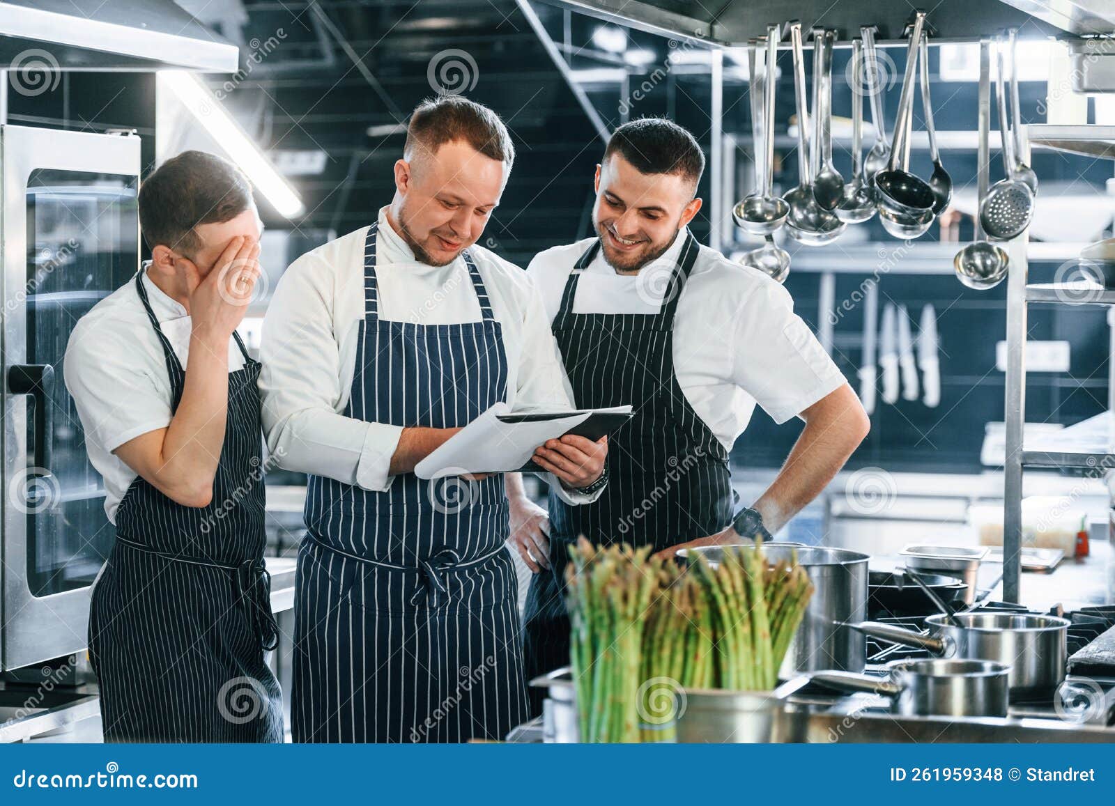 Looking at the Documents. Kitchen Workers is Together Preparing the ...