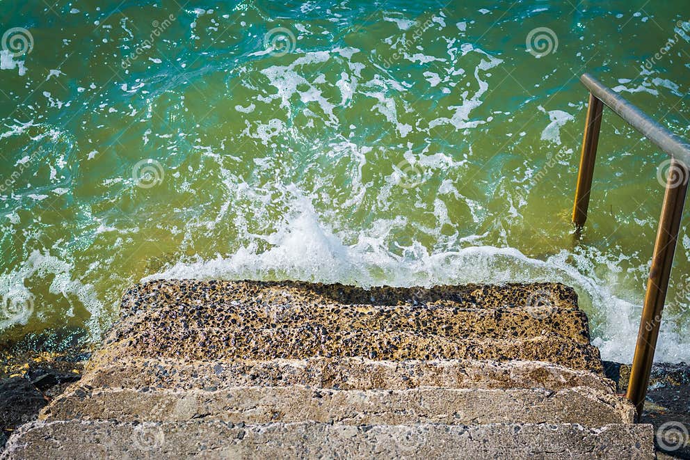 Looking Down the Steps Going into Water As Waves Splash at the Bottom ...