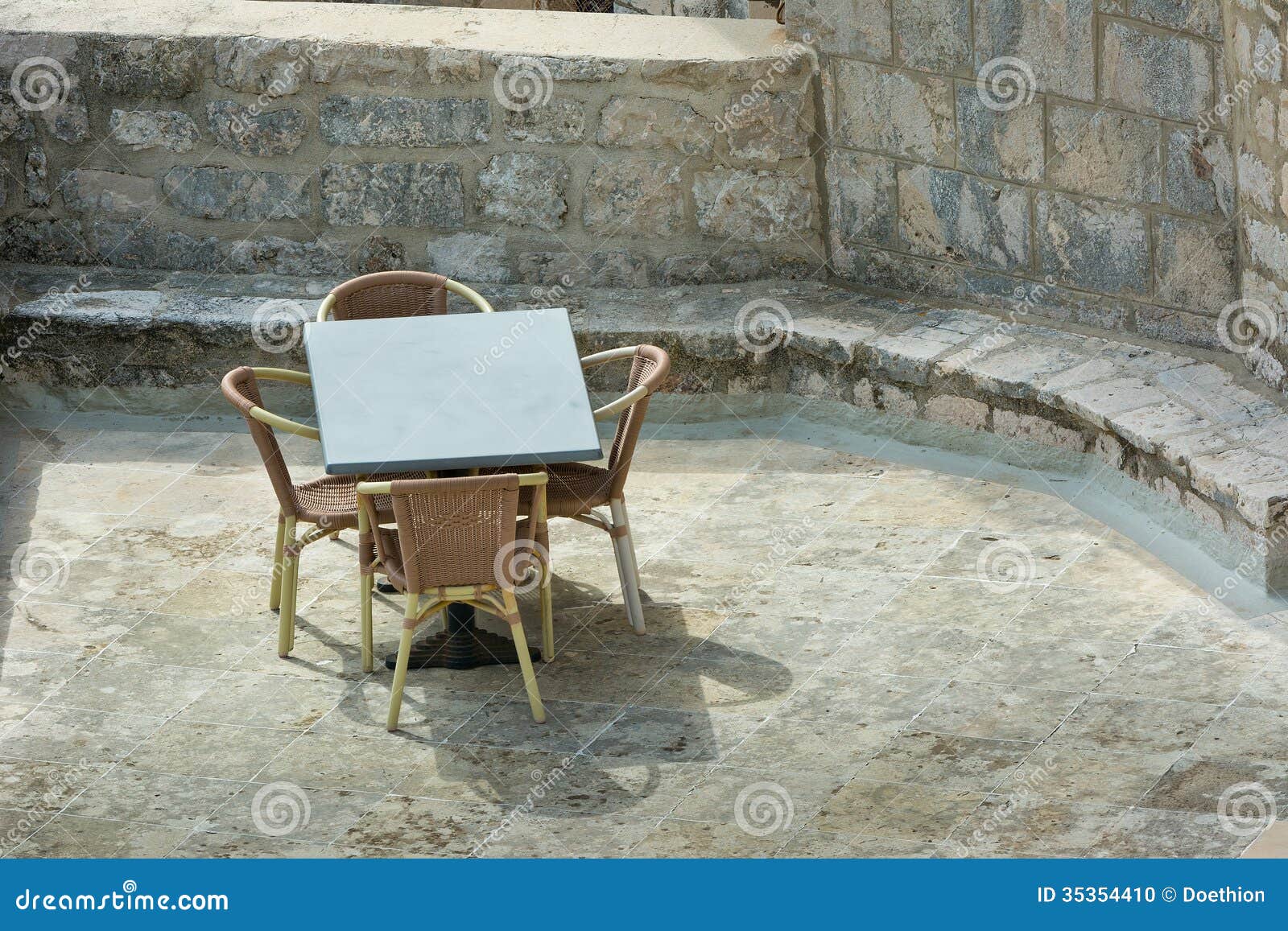 Looking Down on Wicker Table and Chairs in a Ctone Courtyard Sum Stock ...