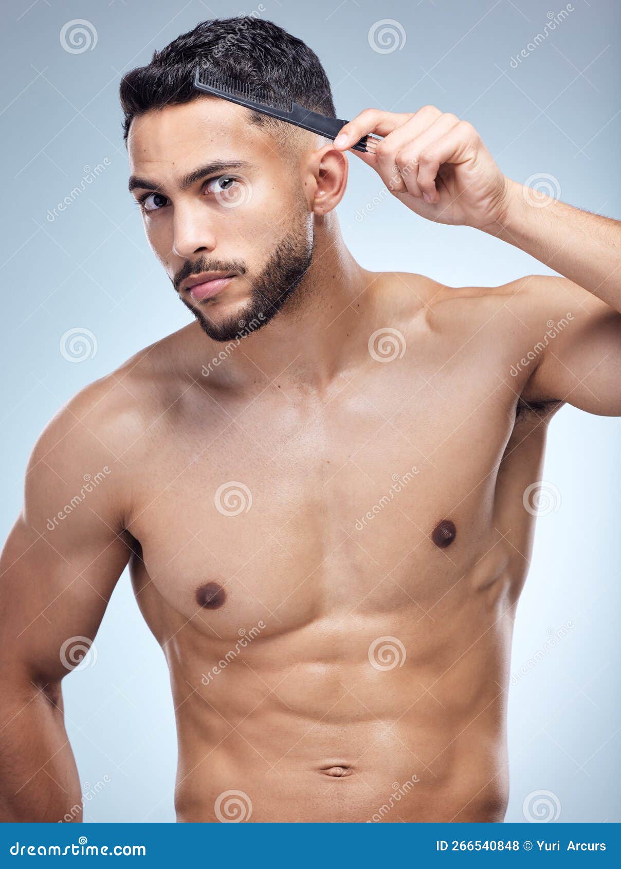 Looking Fly Feeling Fresh. a Young Man Combing His Hair Against Studio ...
