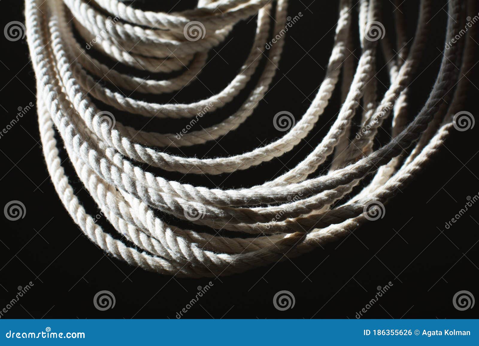 A Lot of Dangling White Cotton Ropes on Black Background Stock Photo ...