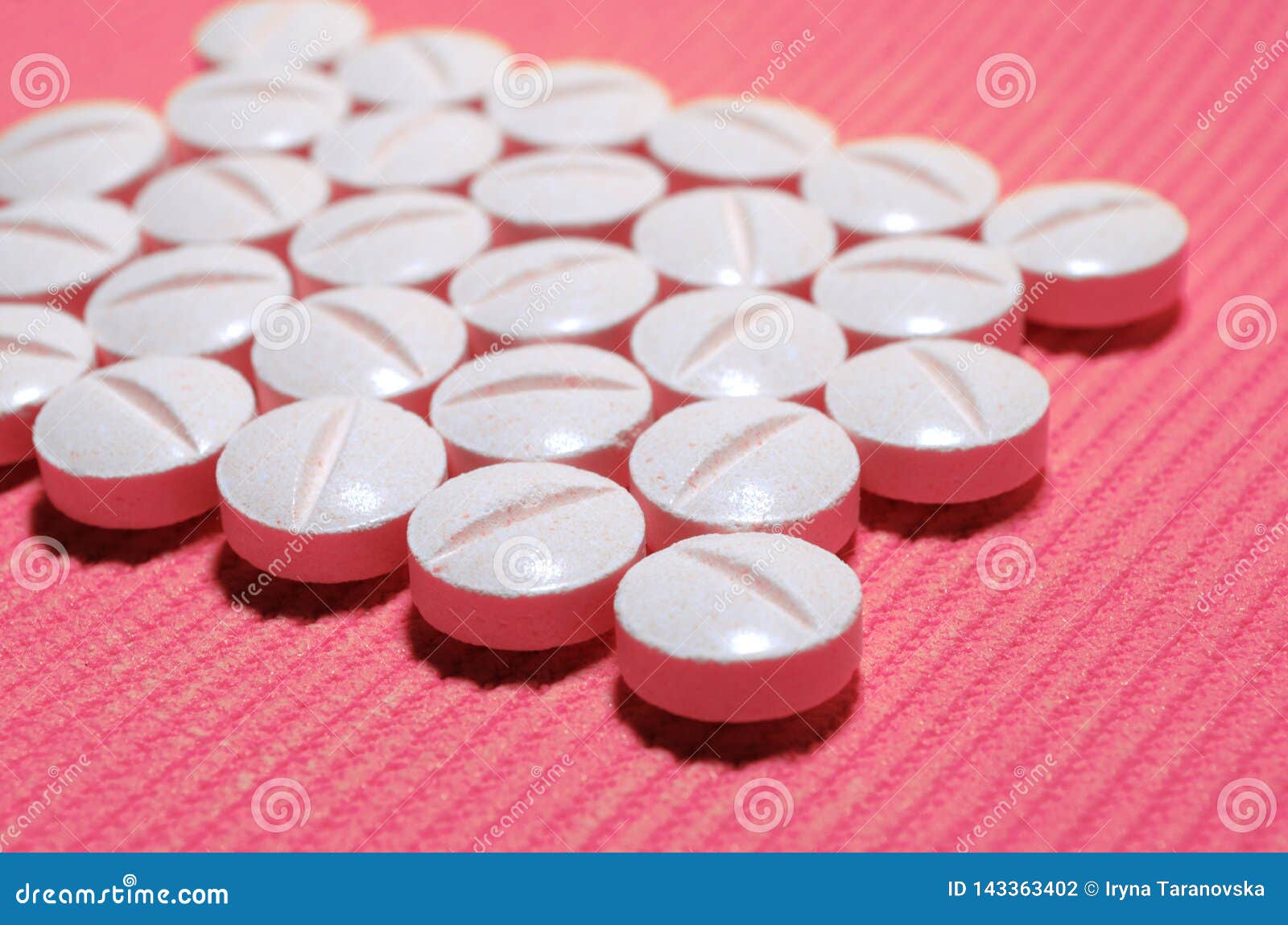 A Lot of White Smooth Convex Tablets with a Dividing Strip on a Pink ...