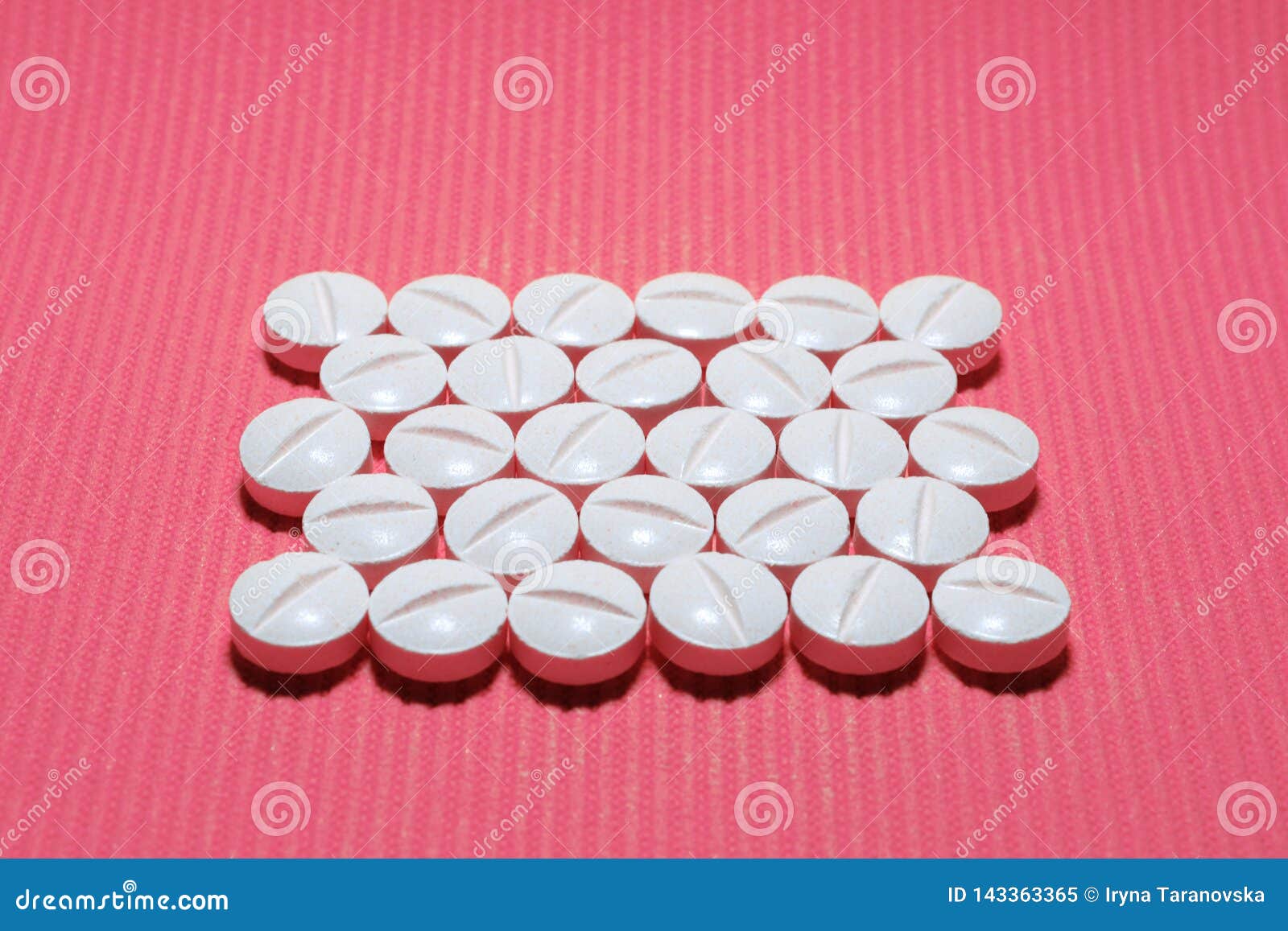 A Lot of White Smooth Convex Tablets with a Dividing Strip on a Pink ...