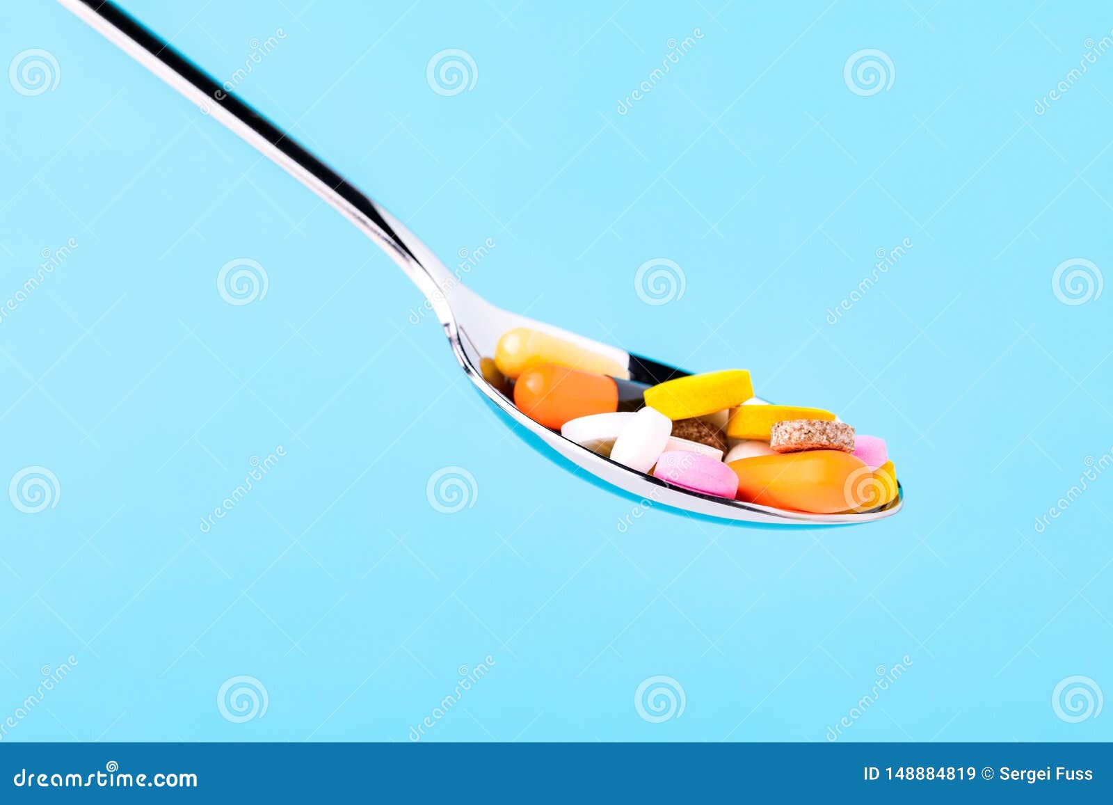 Lots of Tablets on Spoon Isolated on Blue Background Stock Image ...