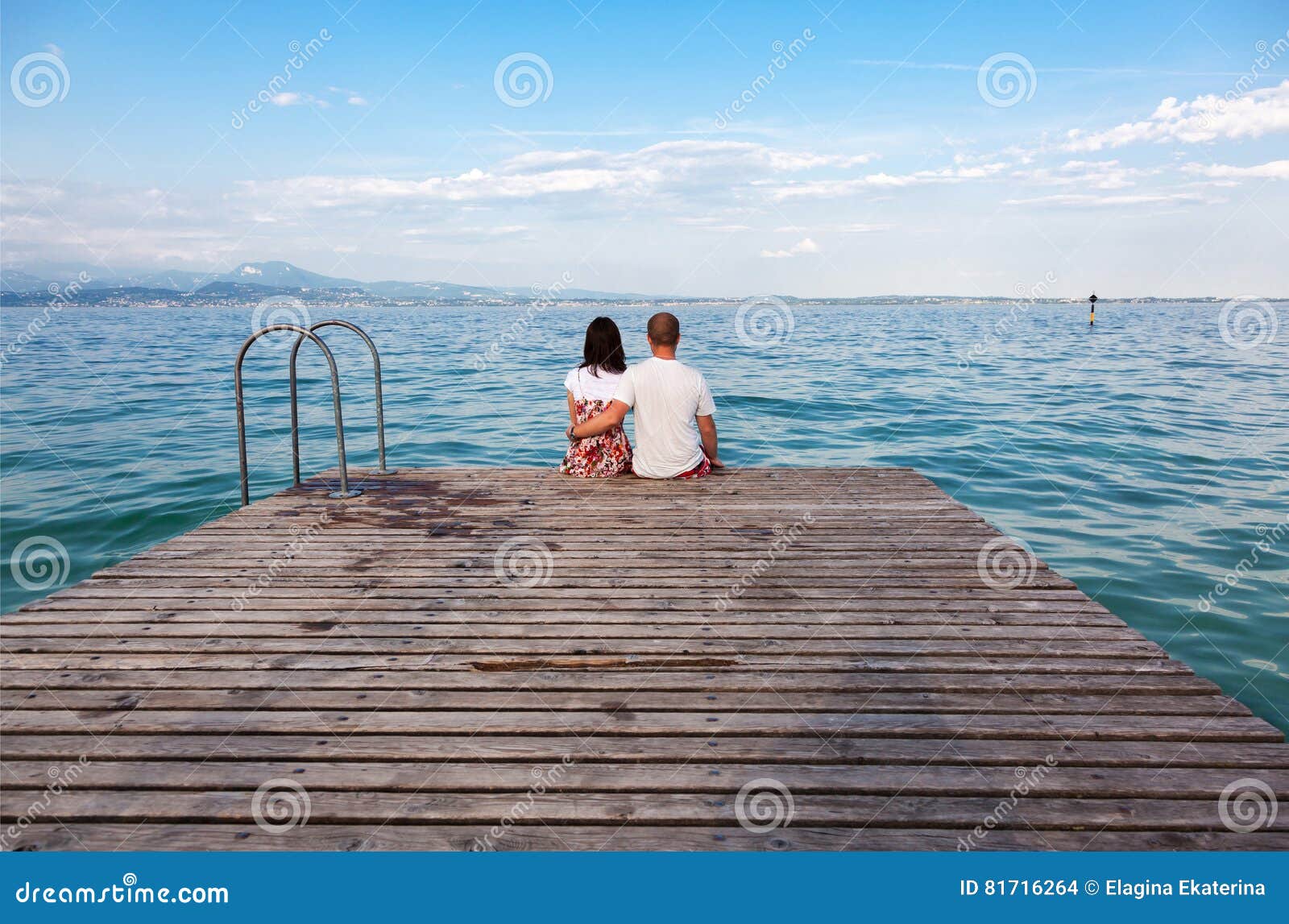 Love Couple Sitting on a Pier Overlooking the Sea Stock Photo - Image ...