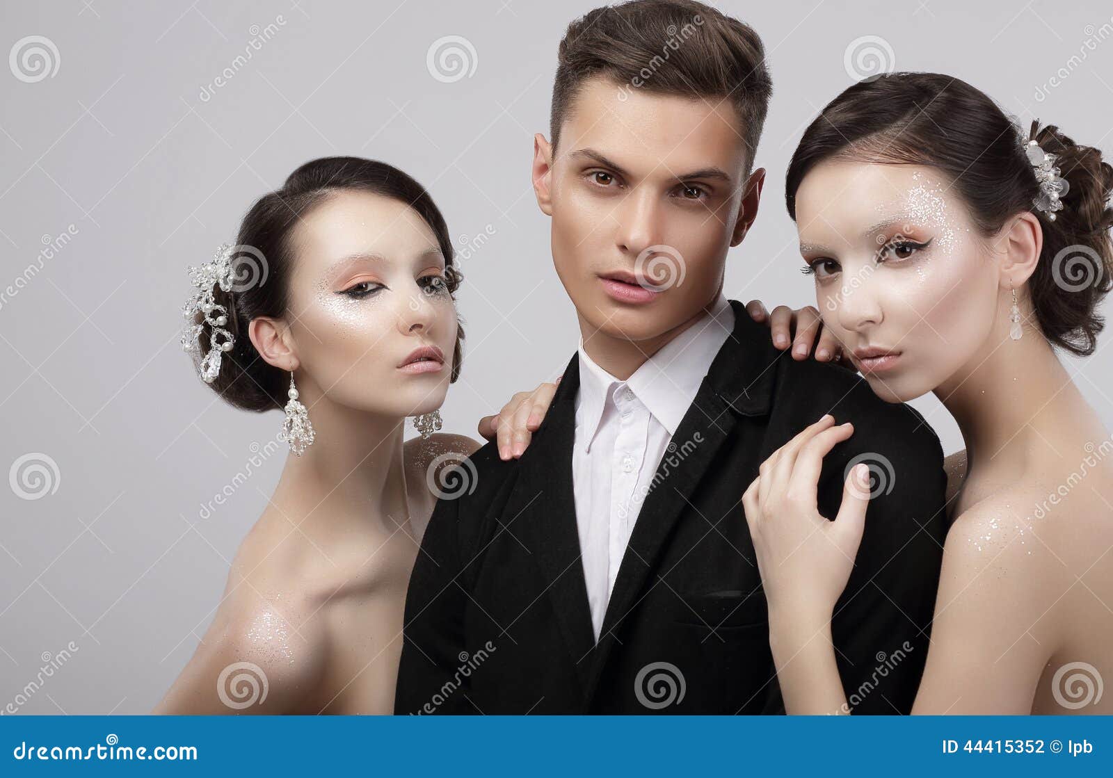 Love Triangle. Two Charming Women Hugging a Handsome Man Stock Photo ...