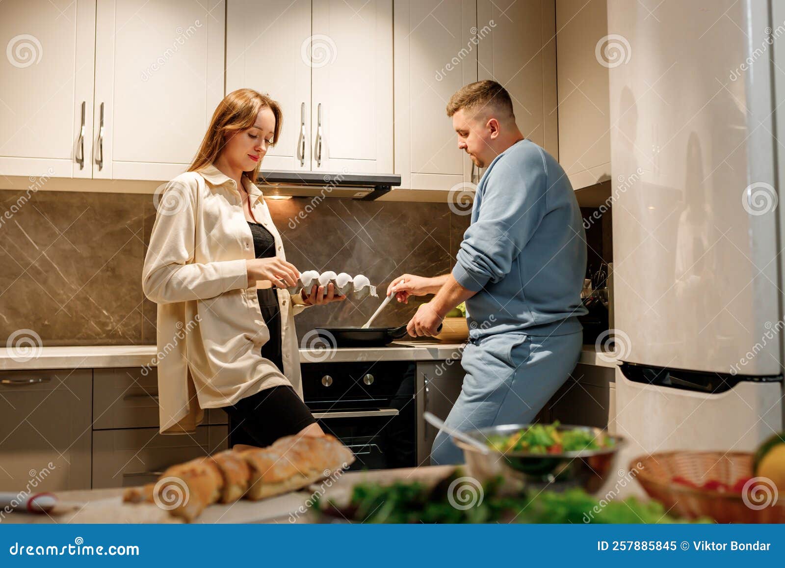Lovely Cheerful Couple Rejoicing While Cooking Breakfast With Eggs