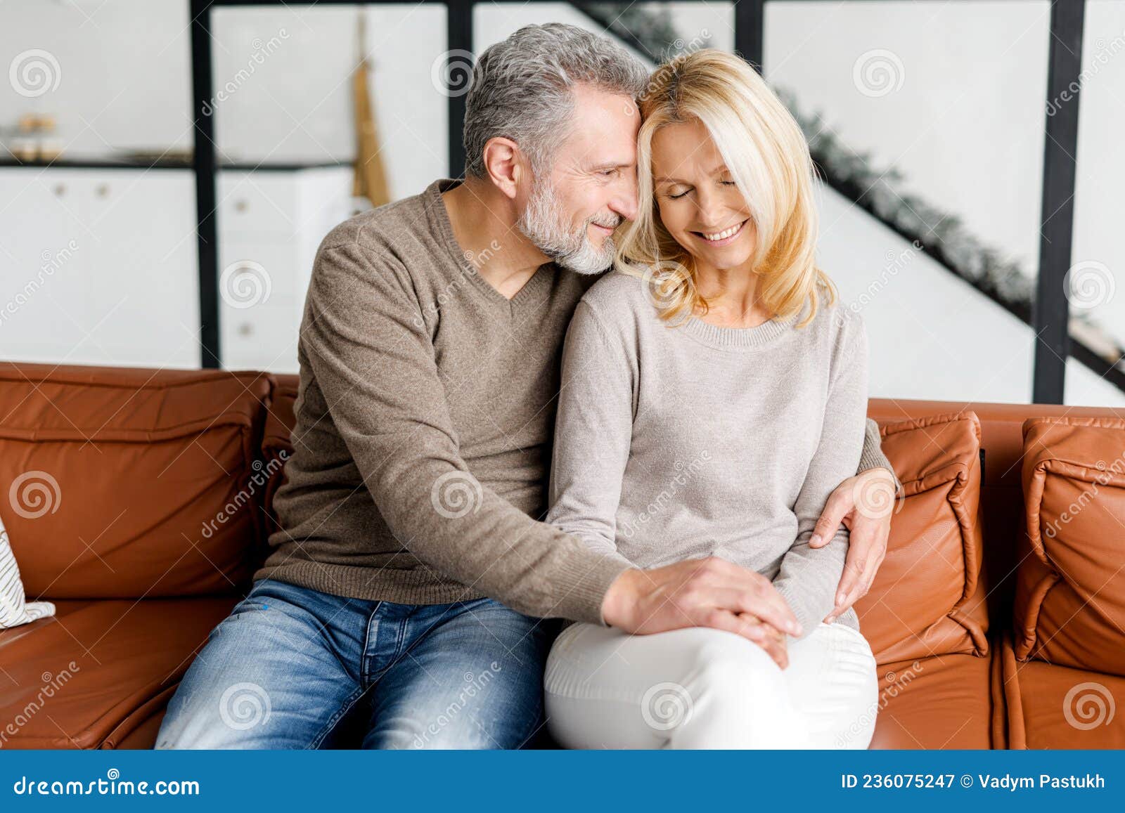 Lovely Middle Aged Couple In Love Sitting In Embrace On The Comfortable