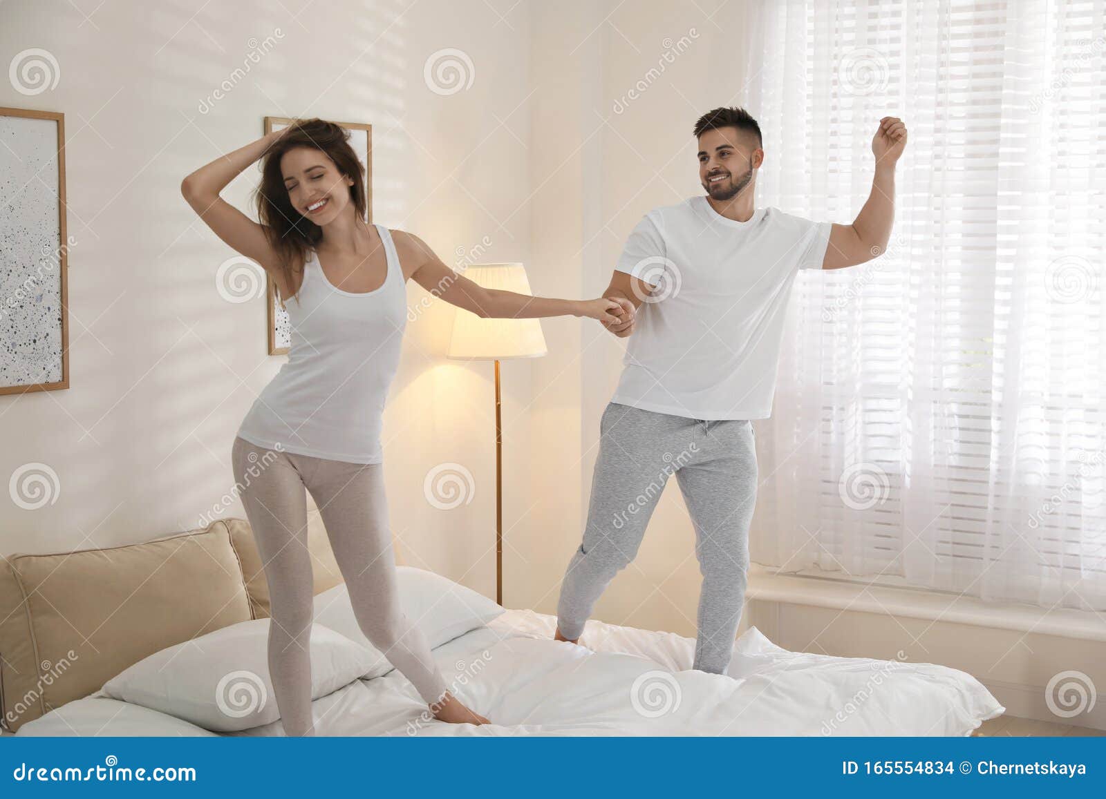 Lovely Young Couple Dancing on Bed Stock Photo - Image of dance ...