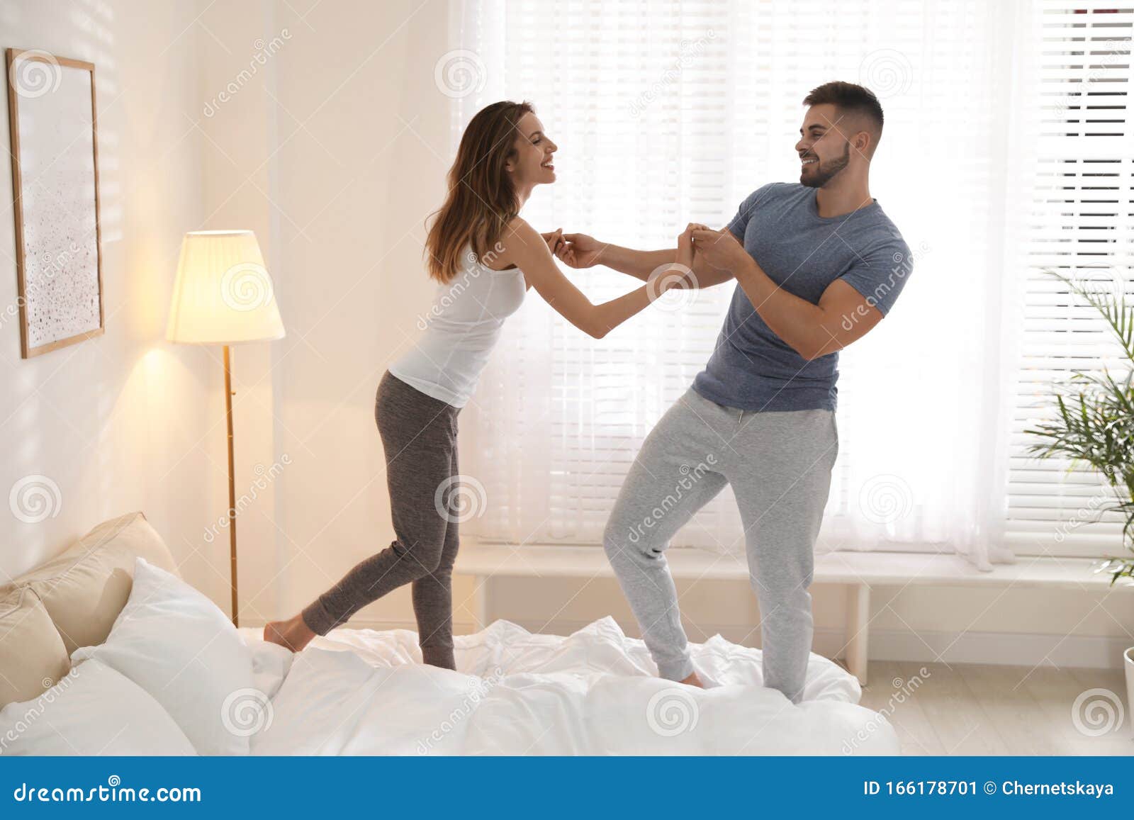 Lovely Young Couple Dancing on Bed Stock Image - Image of caucasian ...