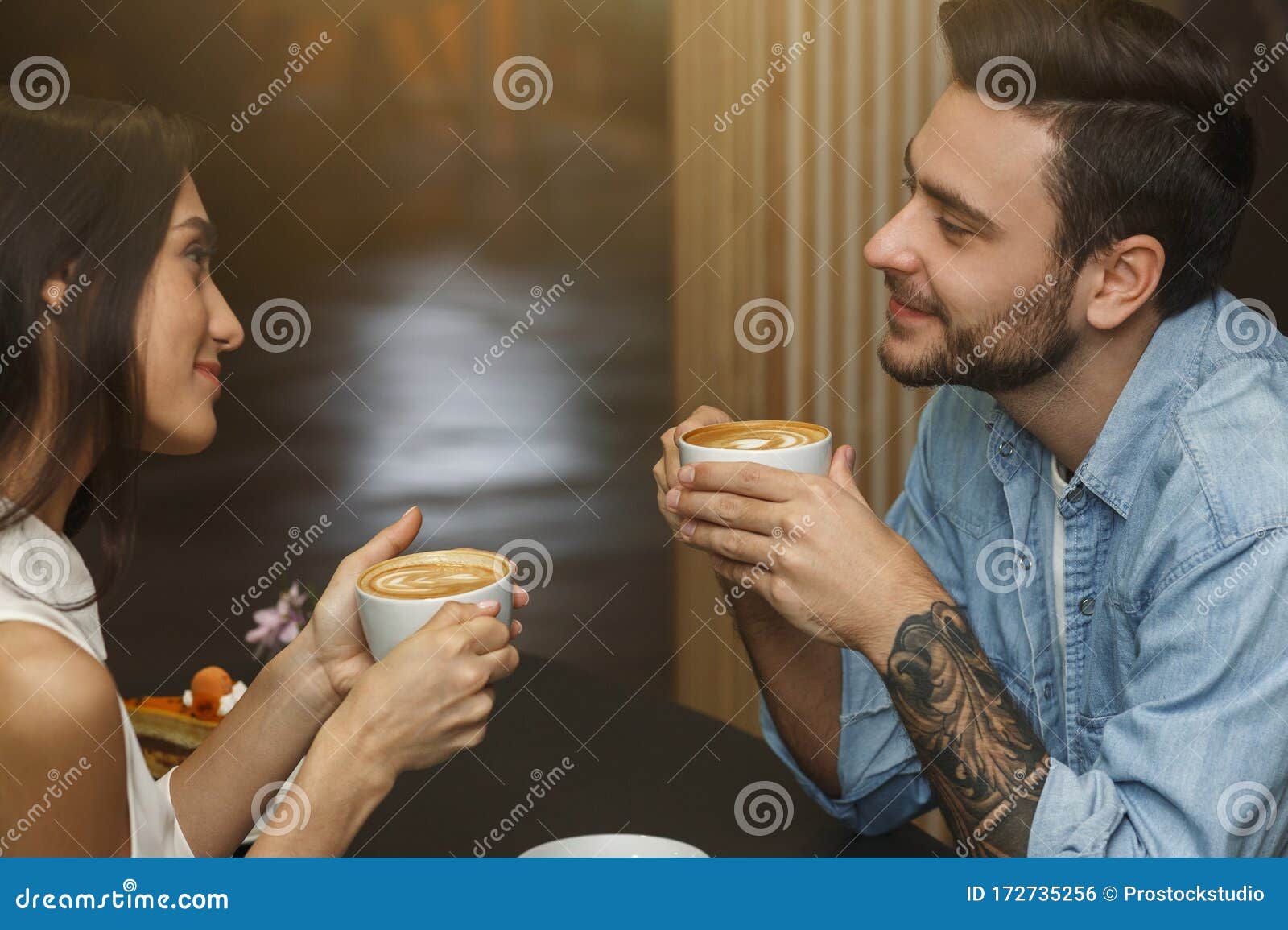Lovers Having Coffee During Date Sitting At Cafe Table Indoor Stock