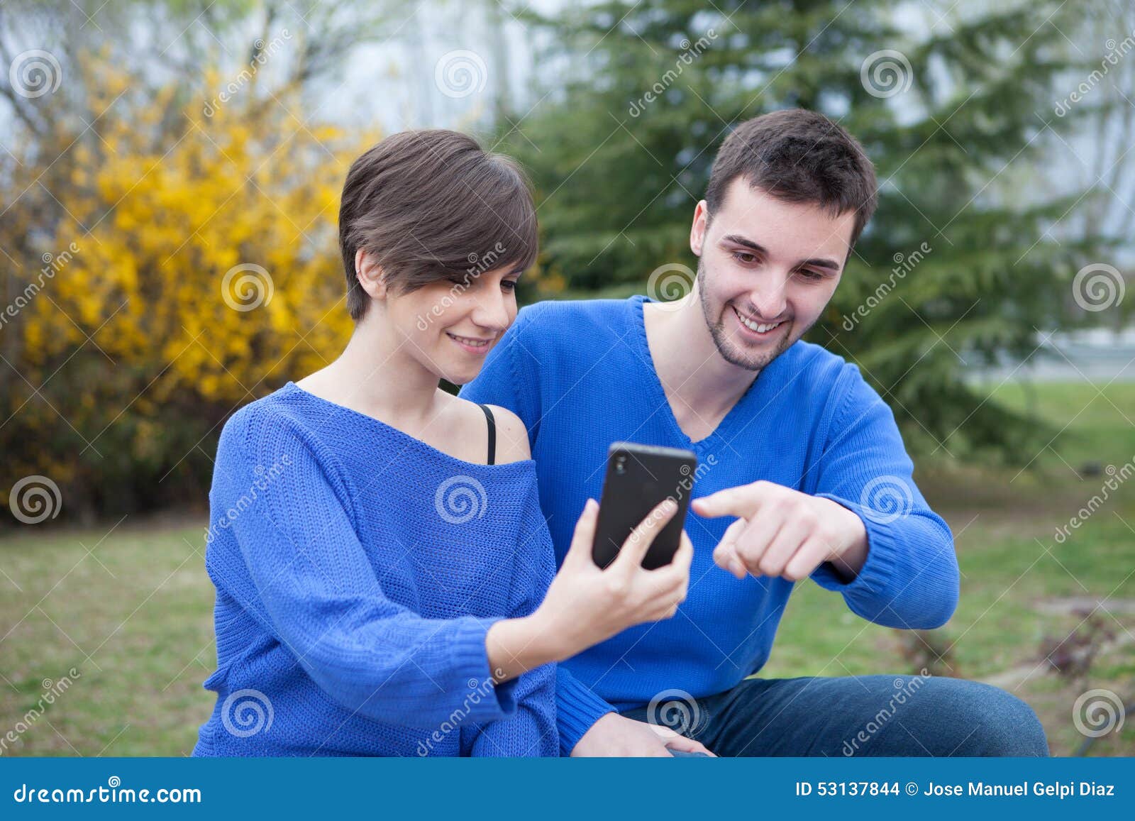 Lovers in the Park Looking the Mobile Phone Stock Photo - Image of ...