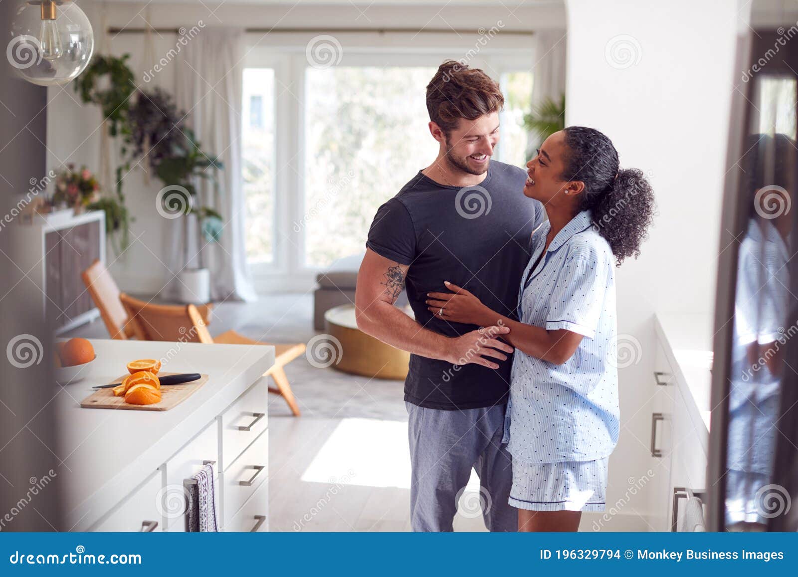 Loving Couple Wearing Pyjamas Hugging in Kitchen at Home Together Stock ...