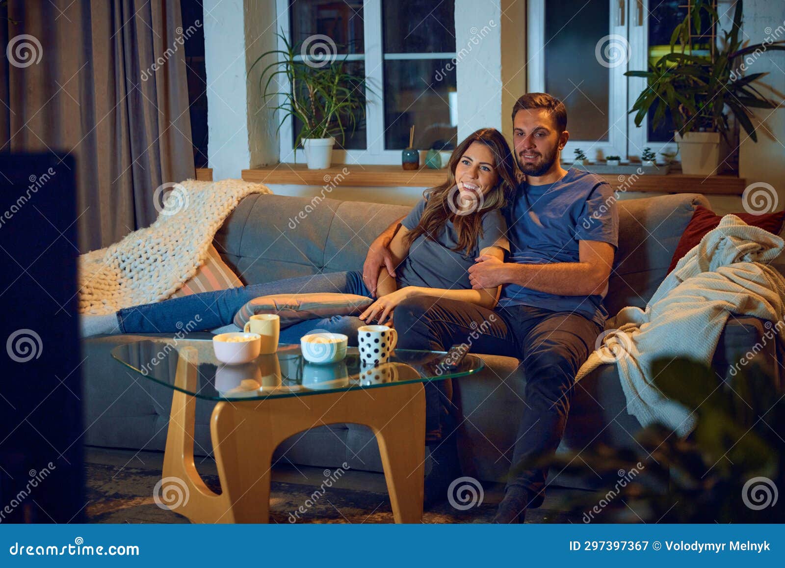 Loving Young Couple Man And Woman Sitting On Sofa In Evening At Home