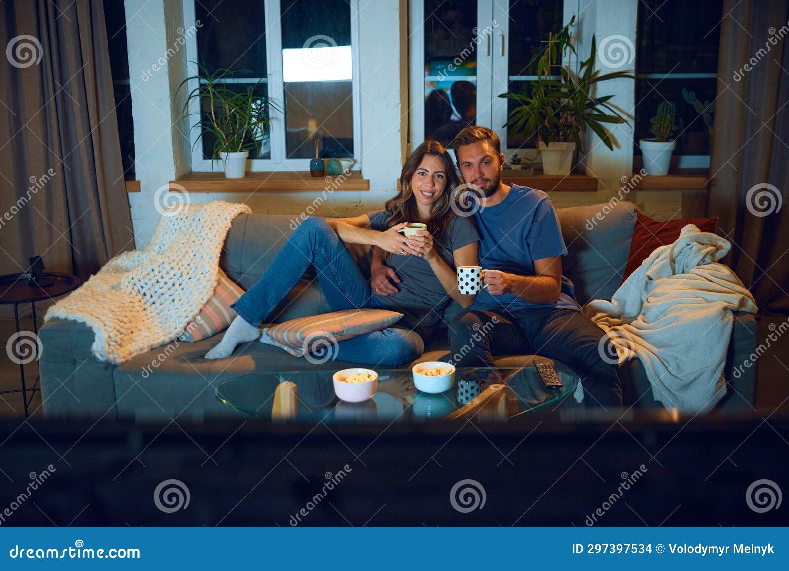 Loving Young Couple Man And Woman Sitting On Sofa In Evening At Home