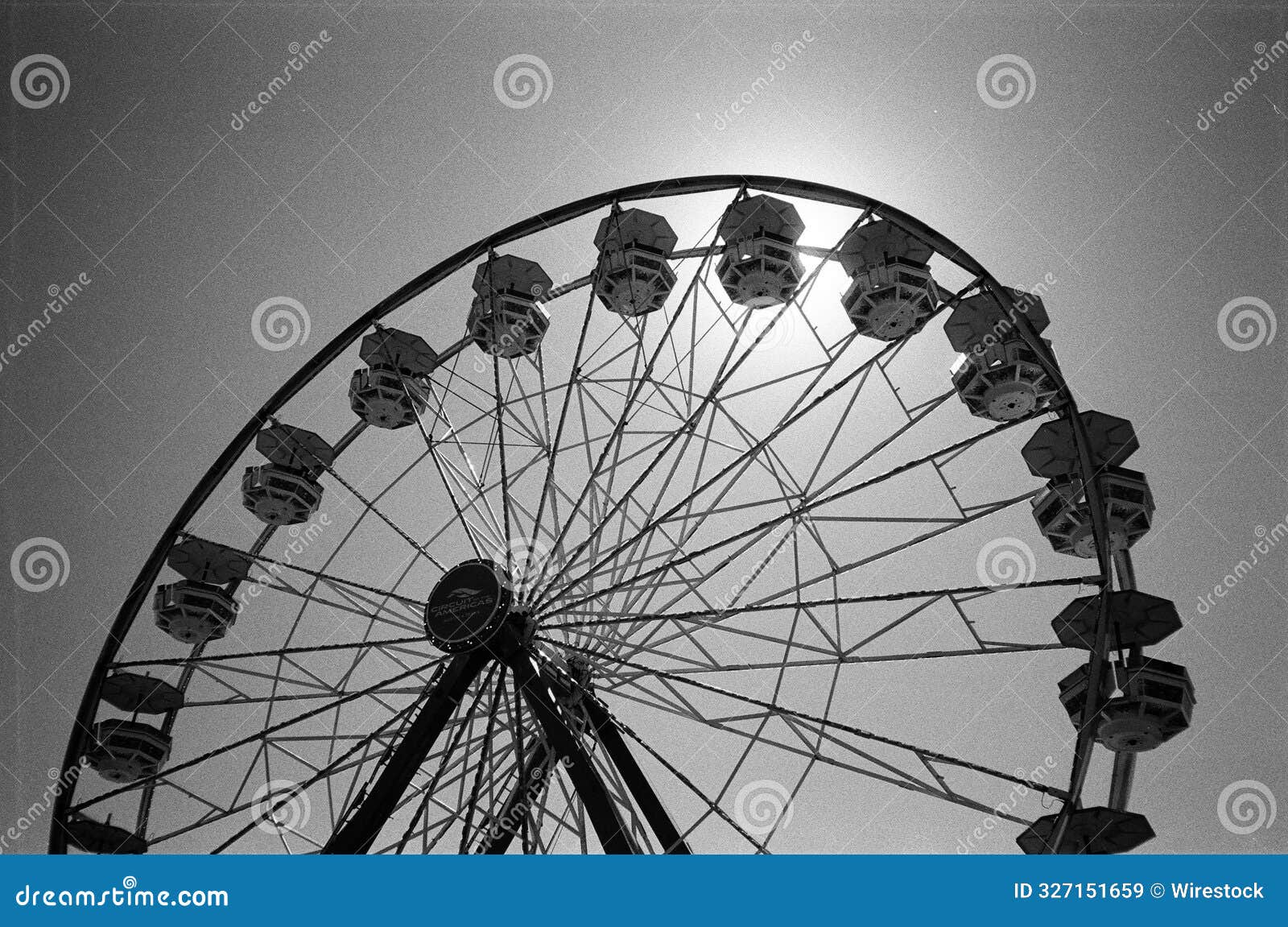 Low Angle Grayscale of a Ferris Wheel with the Sun Shining Behind it ...