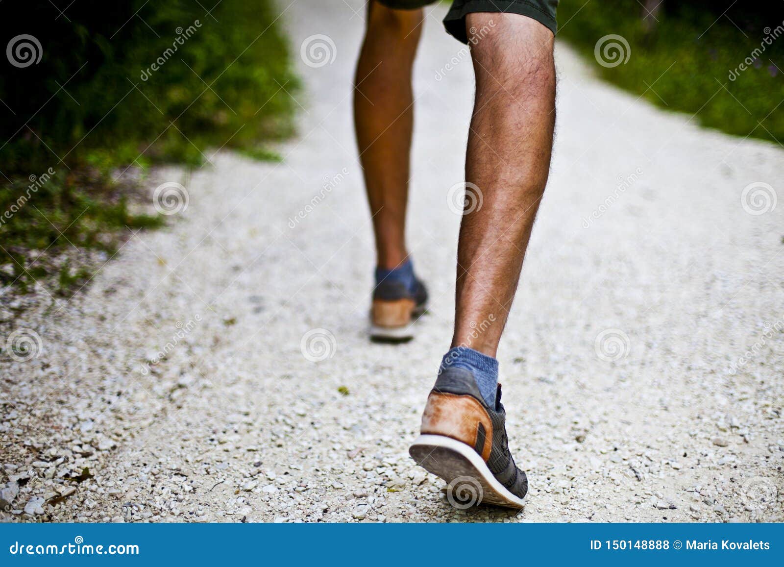 Low Angle Ground Level View with Feet of a Man on Park or Forest Path ...