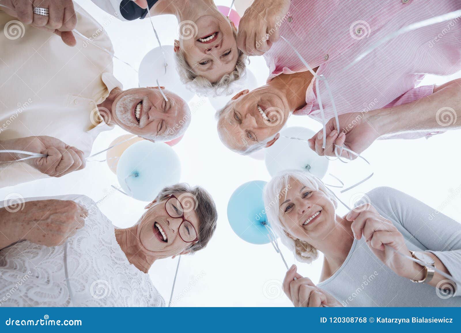 Low Angle Of Happy Senior People In The Circle With Balloons Stock ...