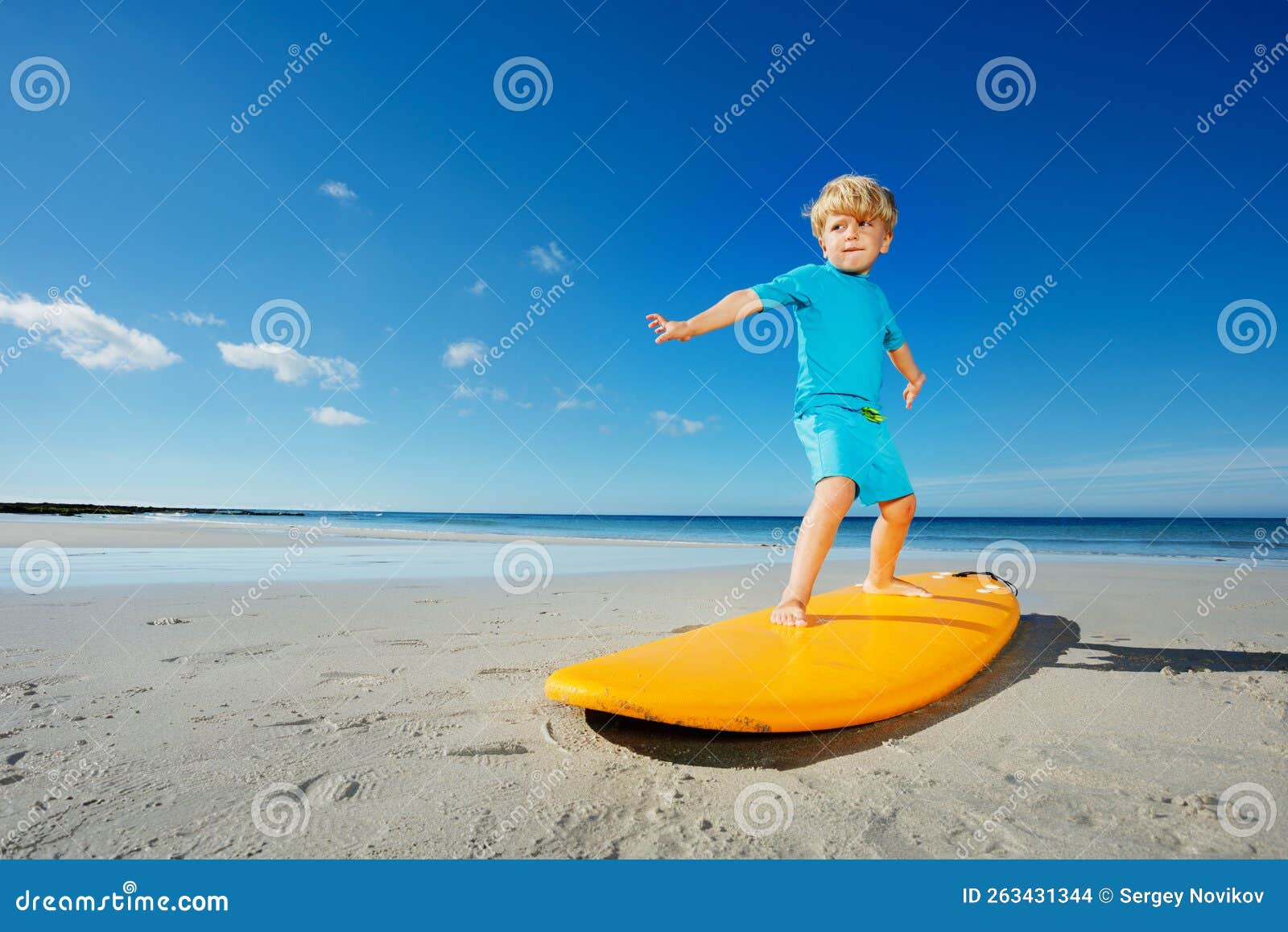 Low Angle Portrait of Blond Boy Stand on the Surfboard at Beach Stock ...