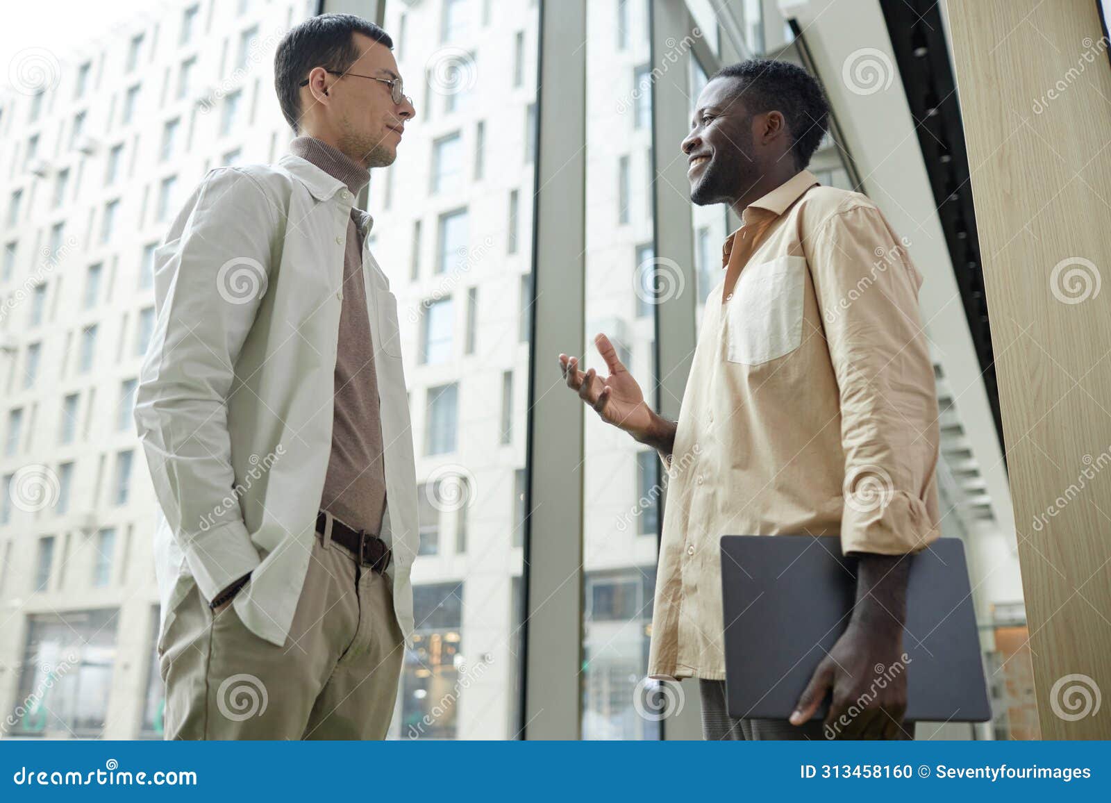 Two Men Chatting by Window at Work Stock Photo - Image of casual ...