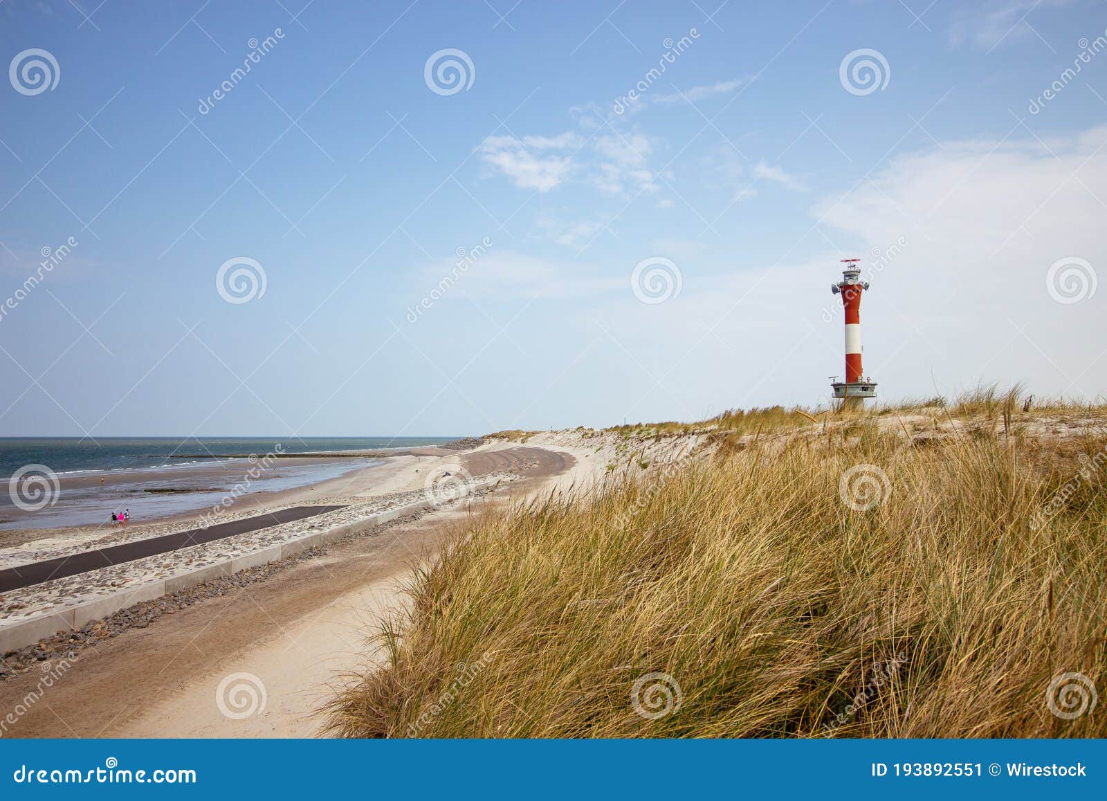 Low Angle Shot of a Beach Ridge, Grassland, and Lighthouse on a Sunny ...