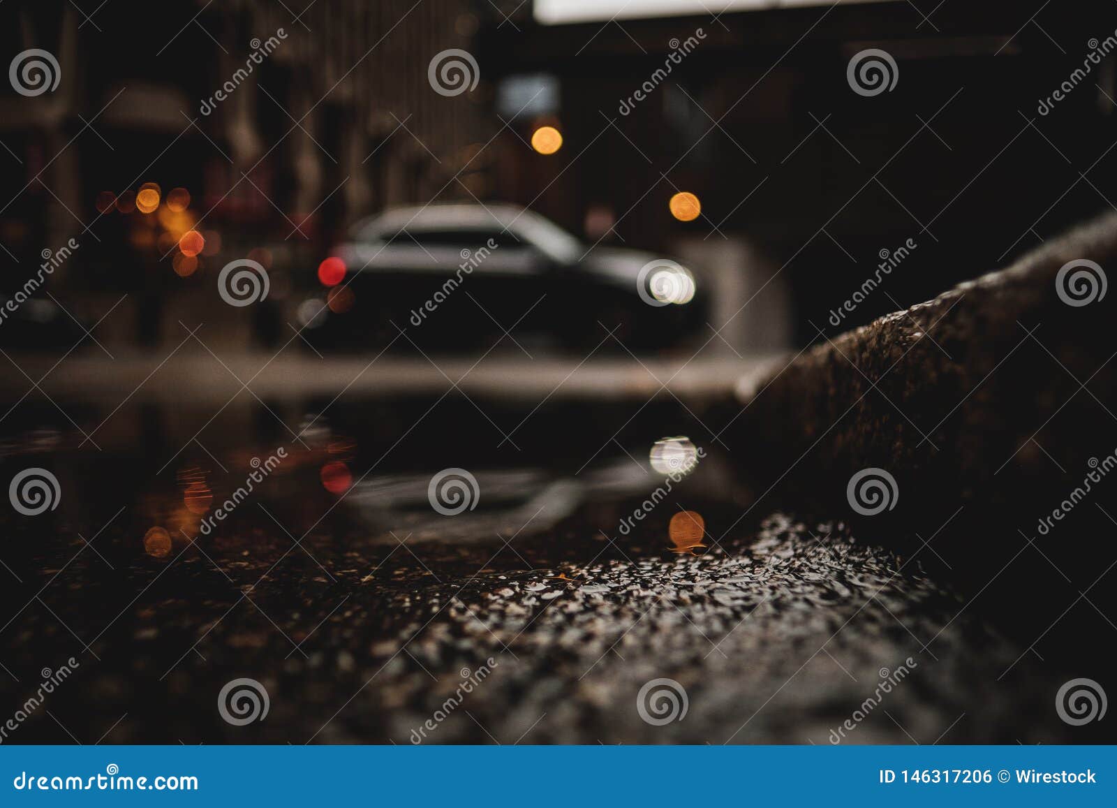 A Low Angle Shot of a Car with Reflection in the Puddle of Water Stock ...