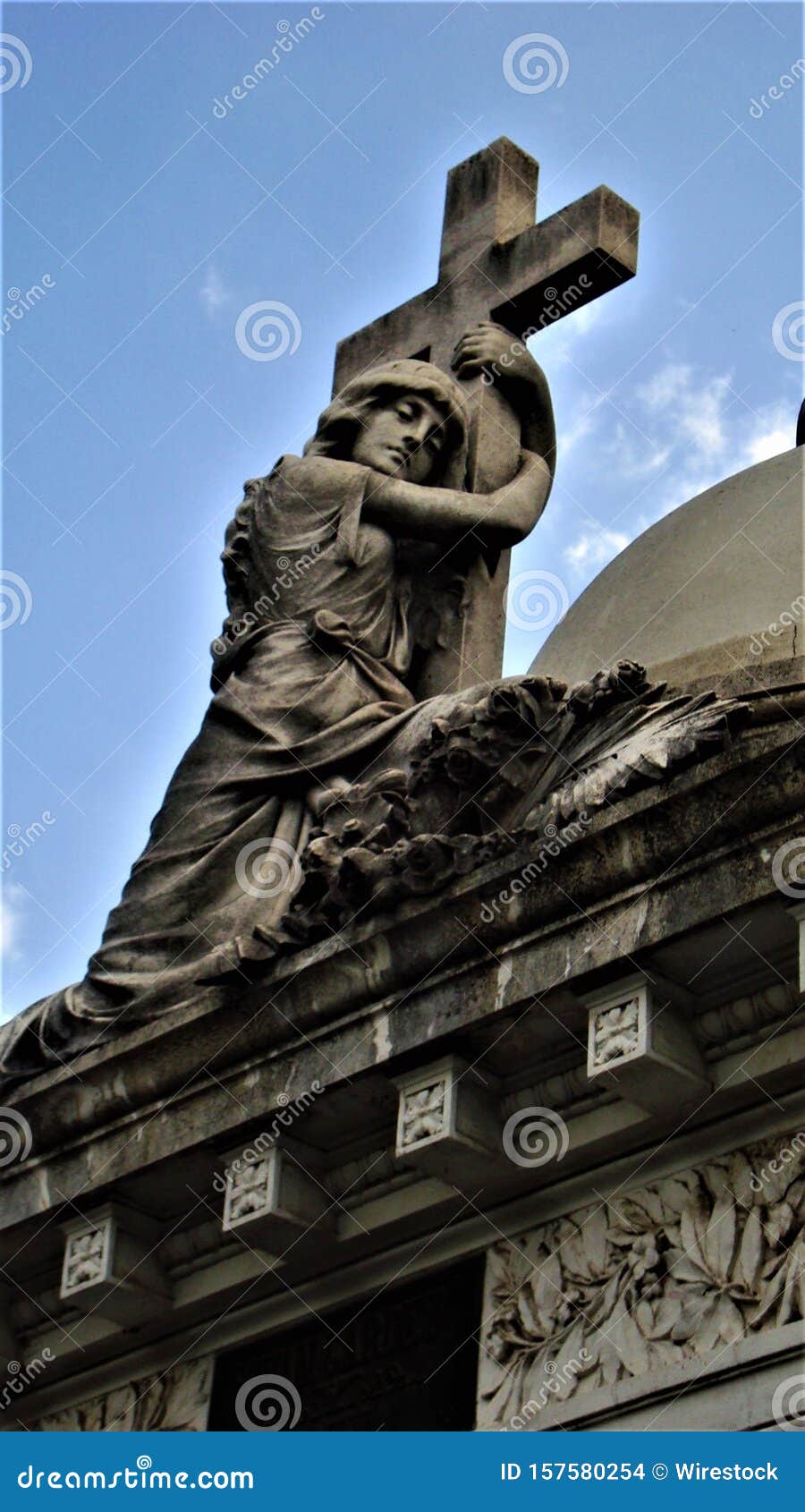 Low Angle Shot of a Female Statue Hugging the Cross on Top of a ...